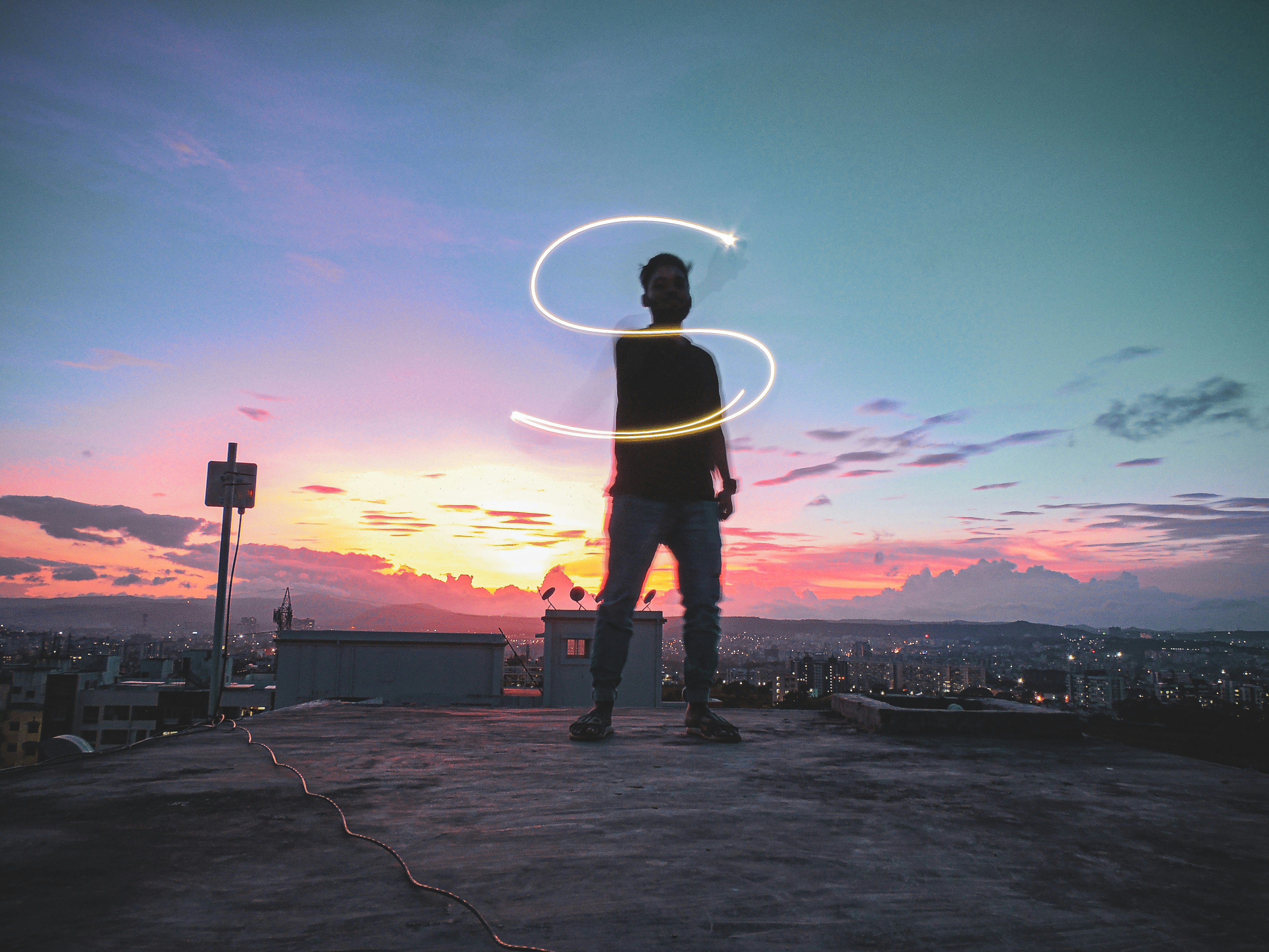 Spiraling Light Graffiti on a Rooftop at Sunset