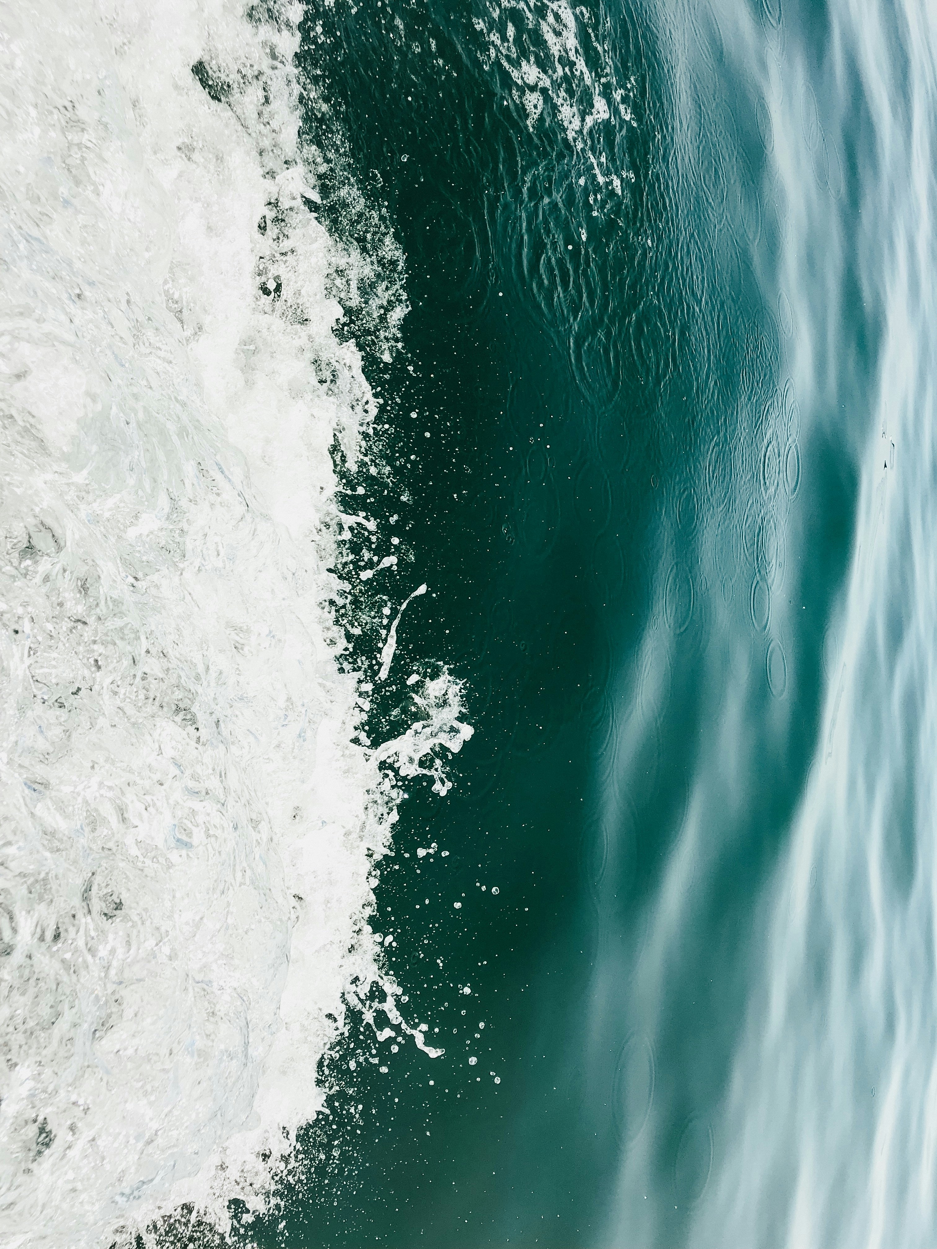 Split Sea: Aerial view of a curling turquoise wave.