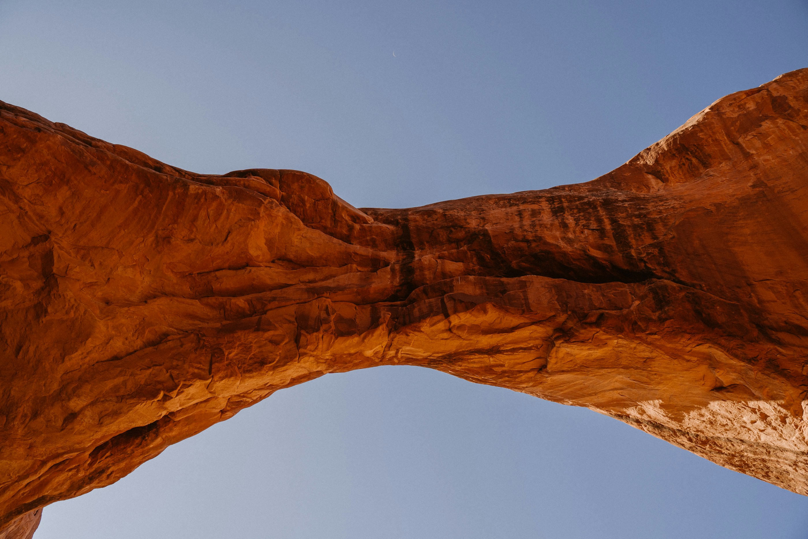 Crimson Stone Arch Framing a Stark Blue Sky