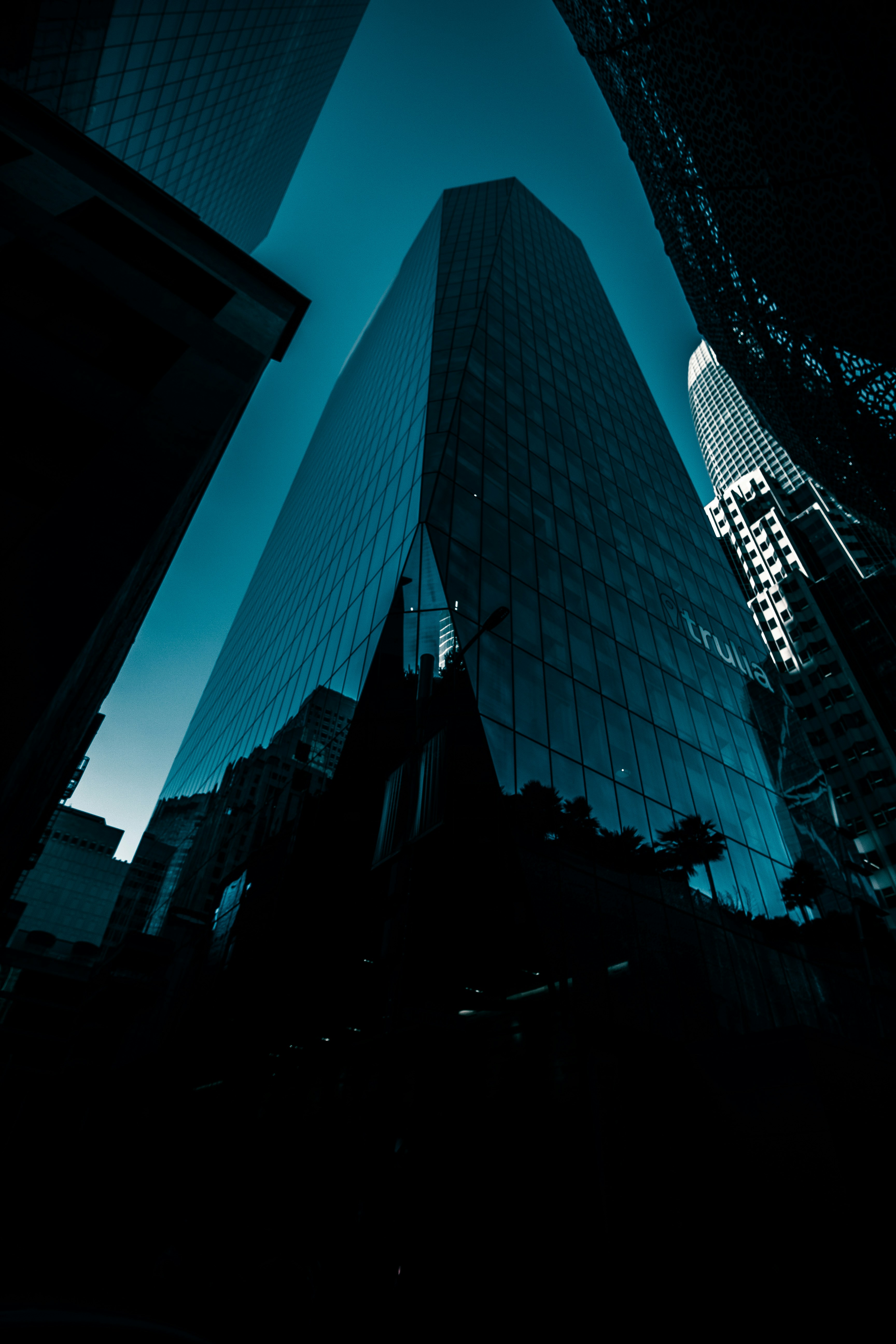 A very tall building towering over a city photo – Free Architecture ...