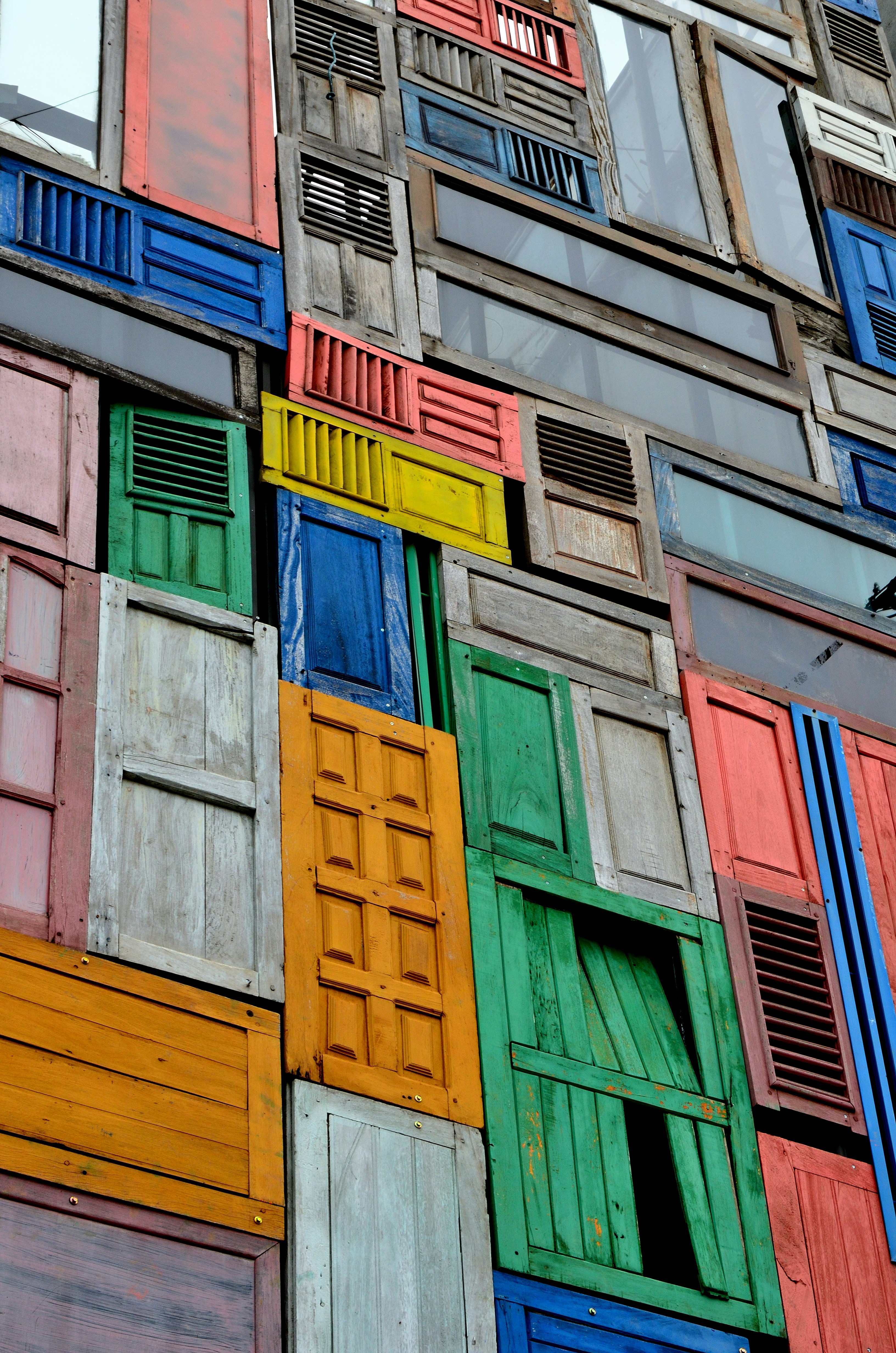Patchwork Facade: A Tapestry of Repainted Doors in Bold Urban Color