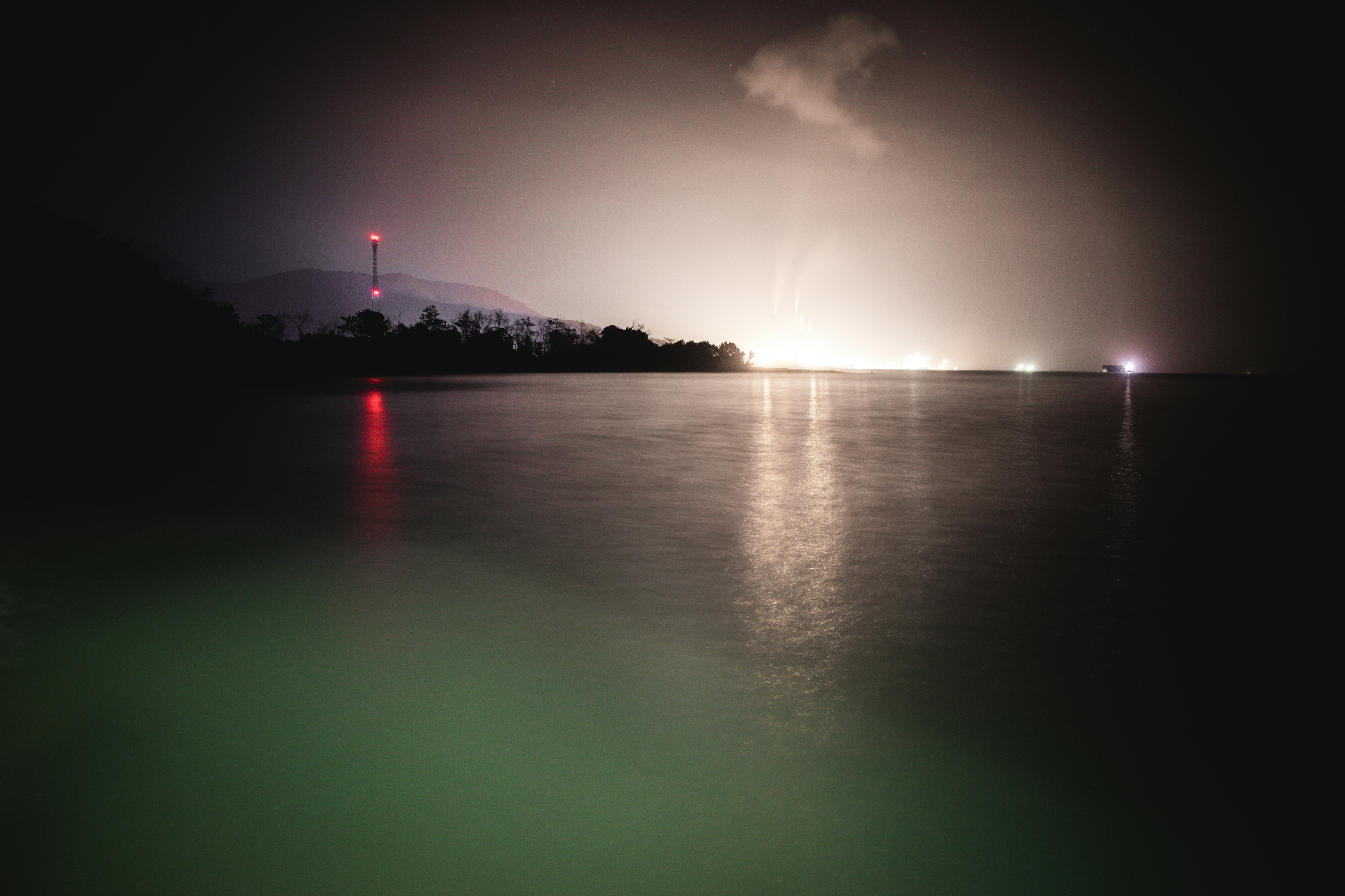 Beacon on the Edge of Night: Long-Exposure Nightscape with Mist and Horizon Glow