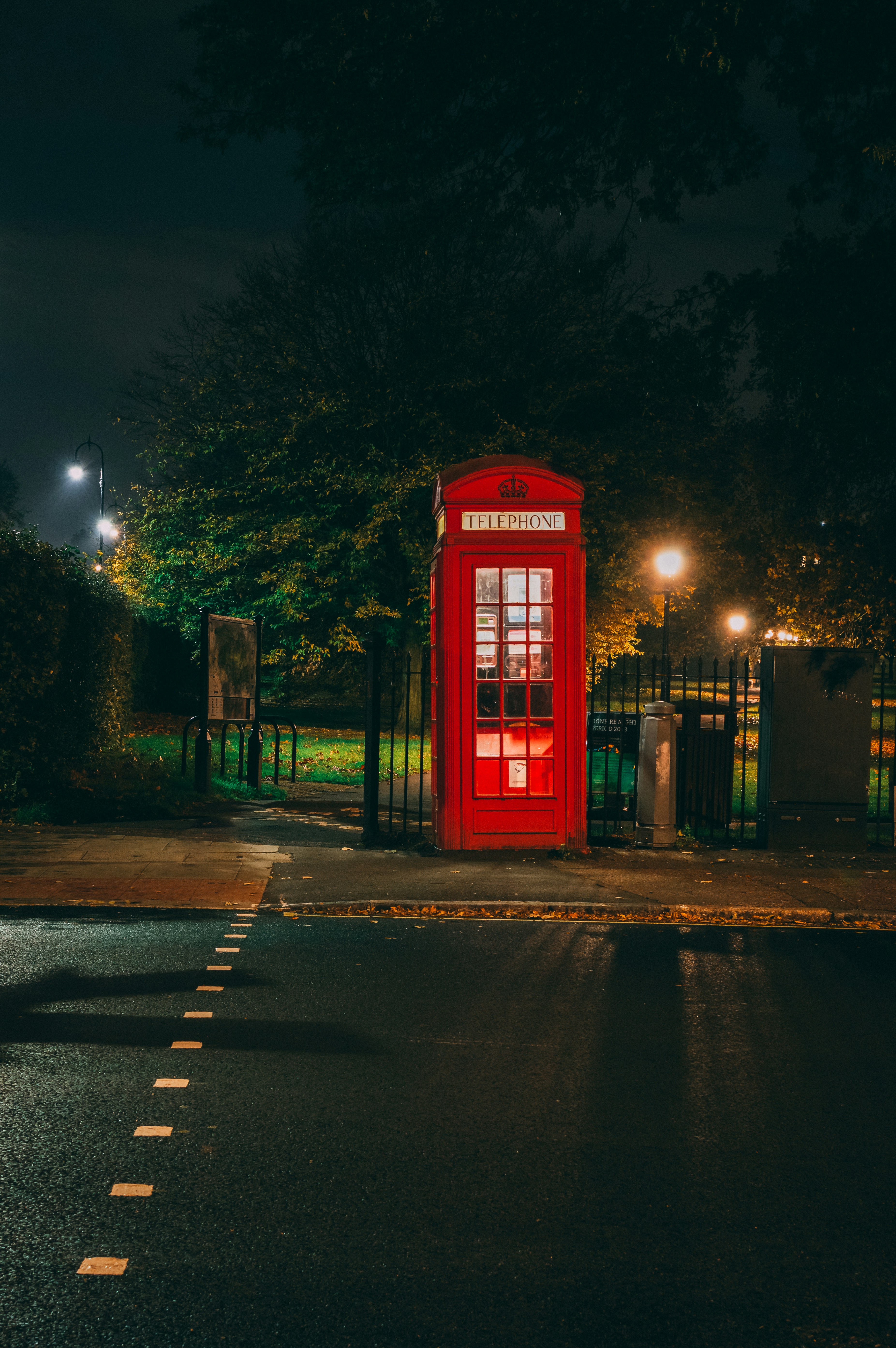 While walking through Primrose Hill, London I found this lighted up telephone box across the street and had to stabilize the camera on a trash can to have a low shutter speed and a sharp image. I really like how the street is clean and the red from the telephone box pops up. | empty red telephone booth at night