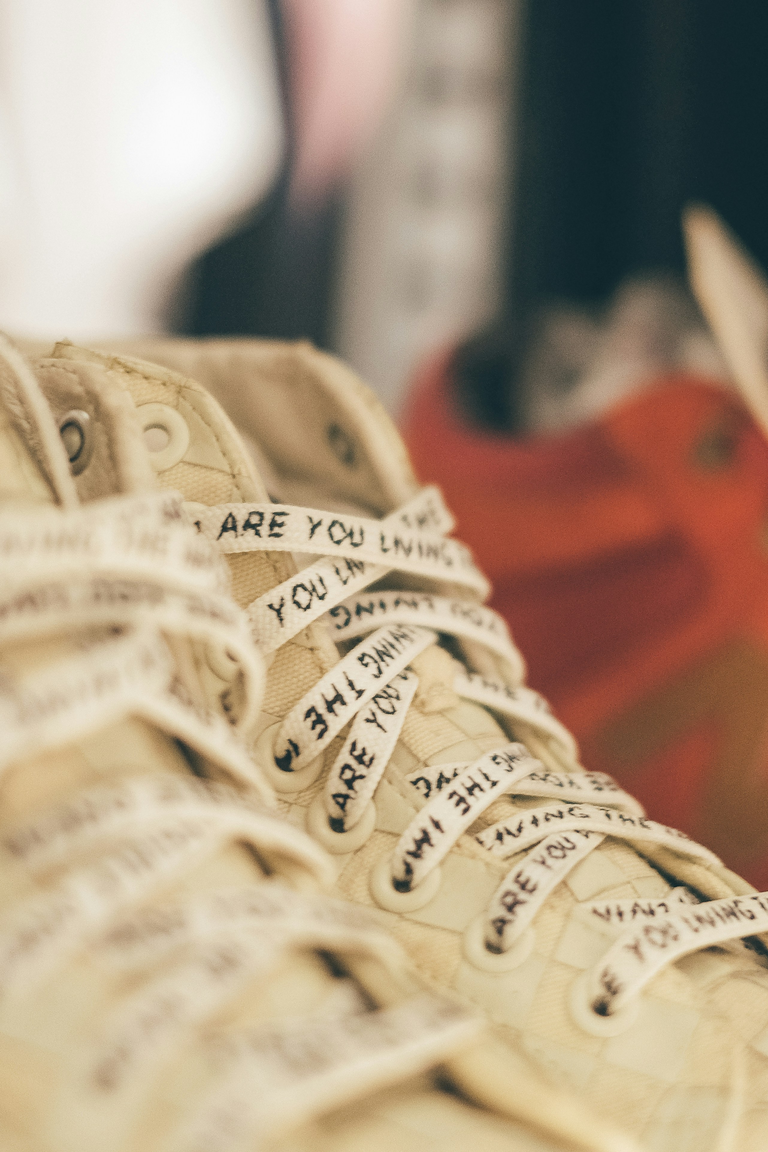 Lace Letters: a close-up of cream sneakers wrapped in printed phrases