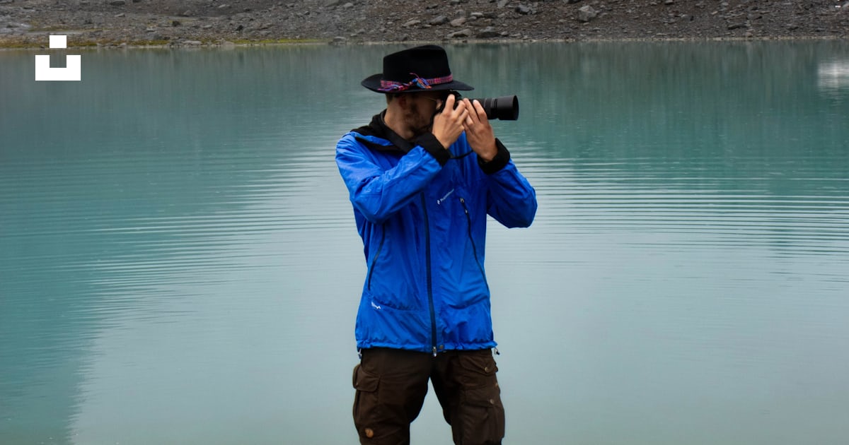 Foto Hombre De Pie En El Cuerpo De Agua Usando Una Cámara Dslr Imagen