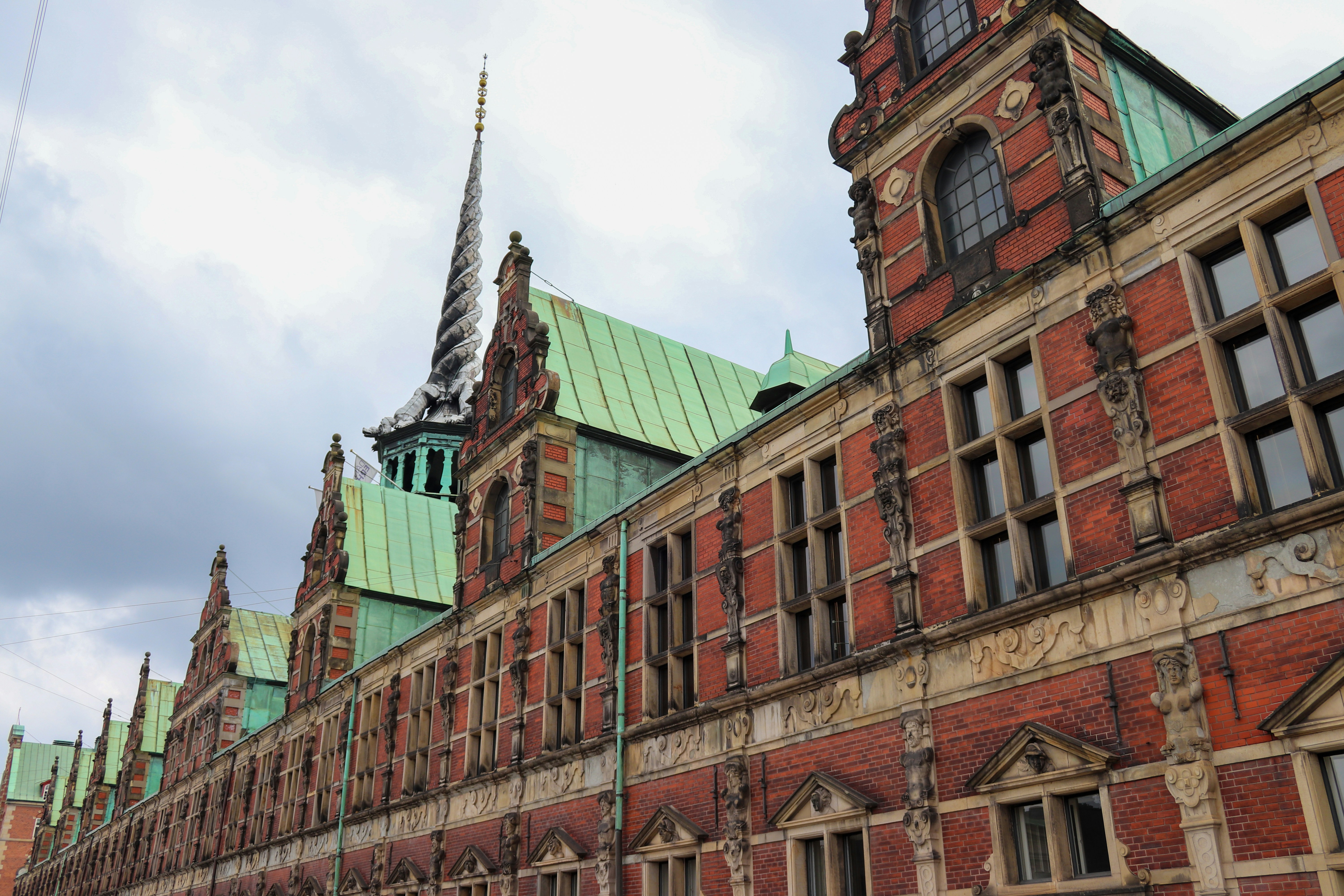 Copper-Roofed Brick Facade Runs Along a Gothic-Revival Arcade
