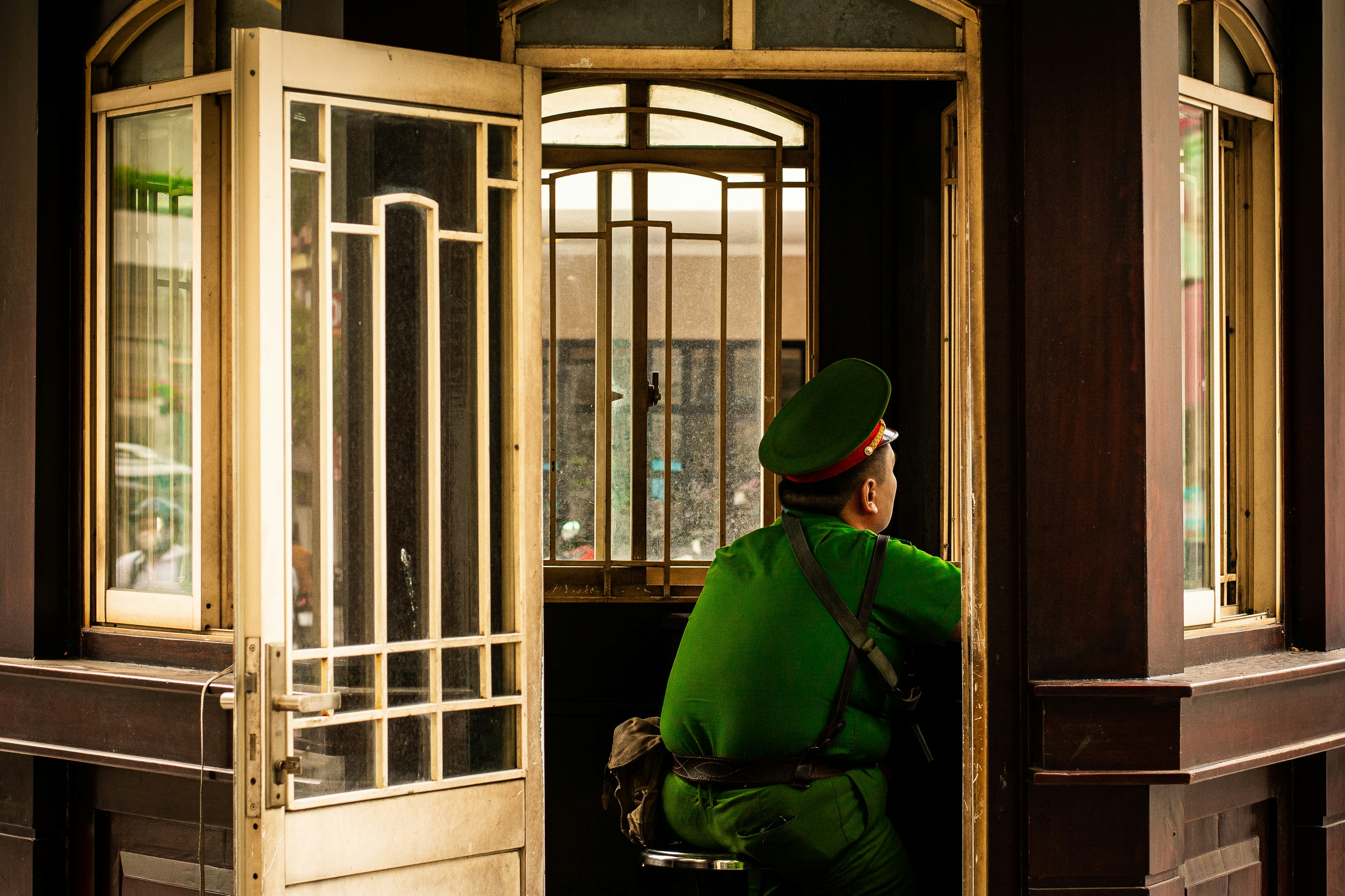 Man sitting inside brown guard house photo – Free Entrance Image on ...