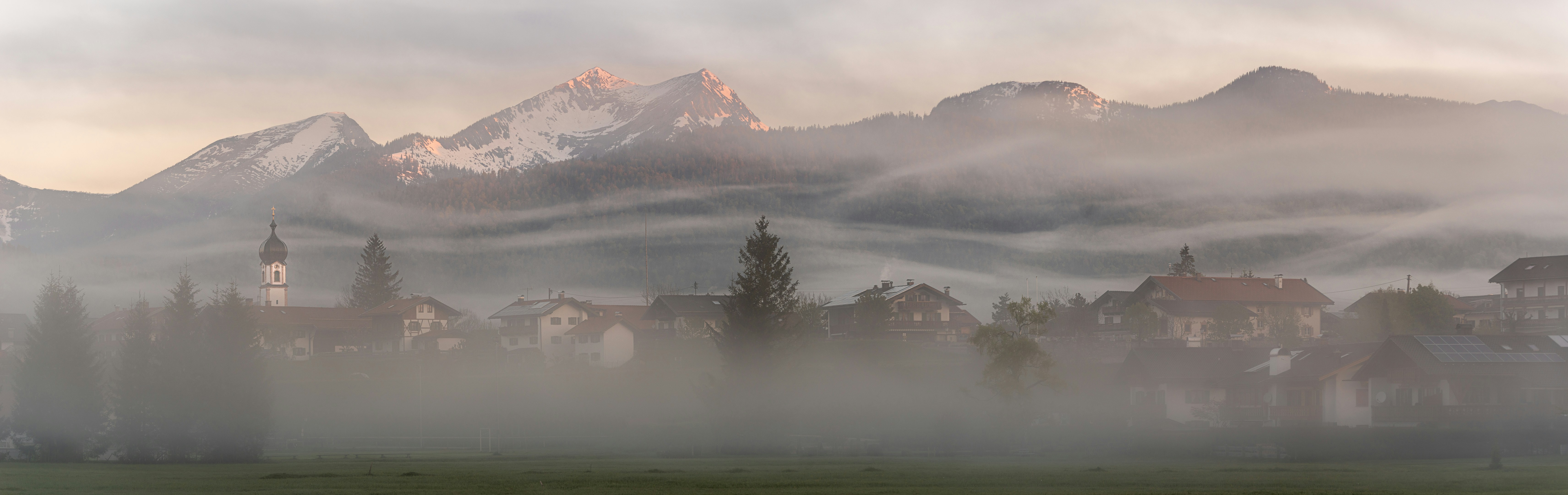 Dawn Veil Over the Alpine Village Beneath Snow-Capped Peaks