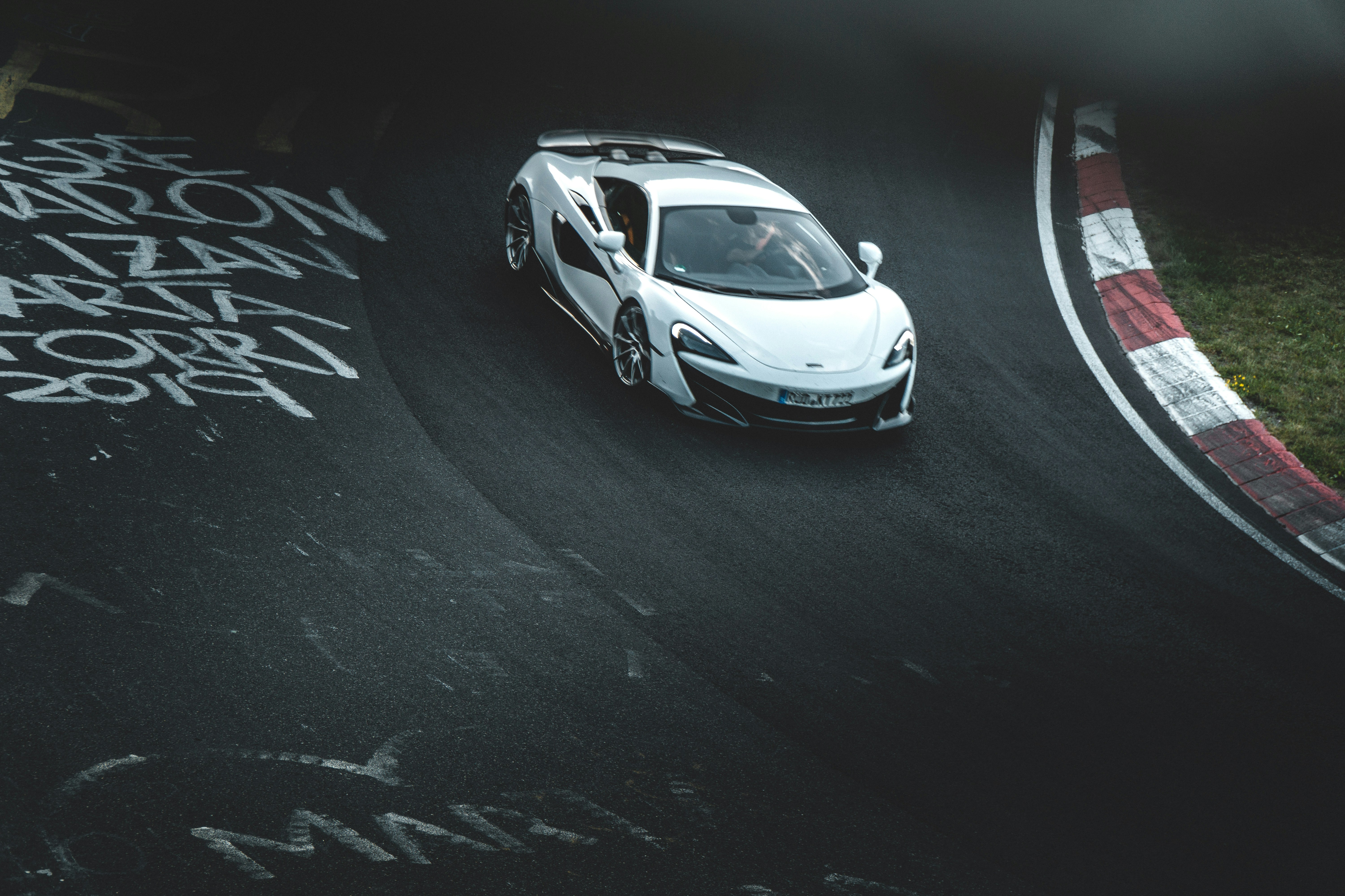 White Apex: A Racecar Bites the Curve on a Shaded Ascent