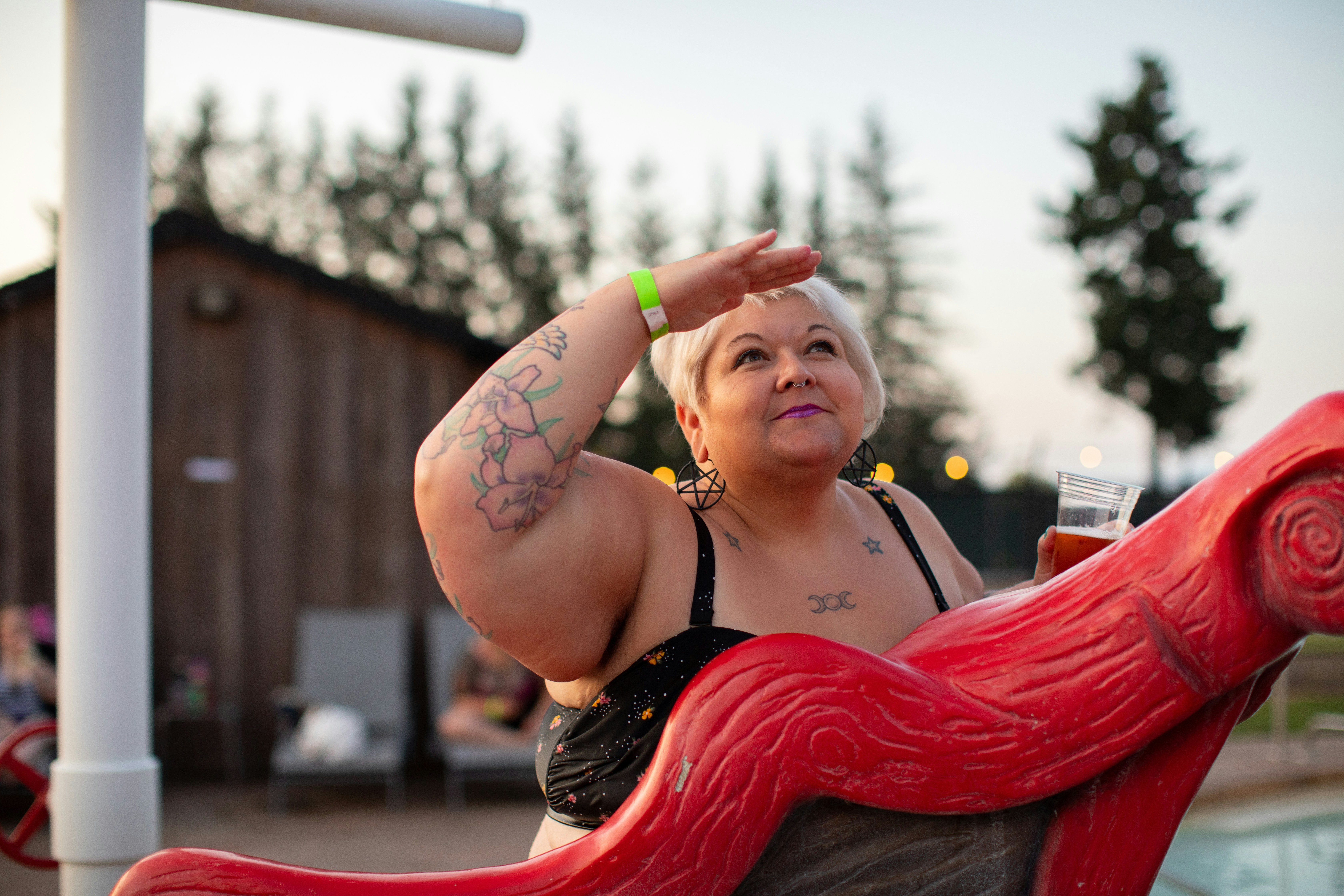 Shielding the Sunset: Portrait on a Red Carved Horse Bench by the Pool