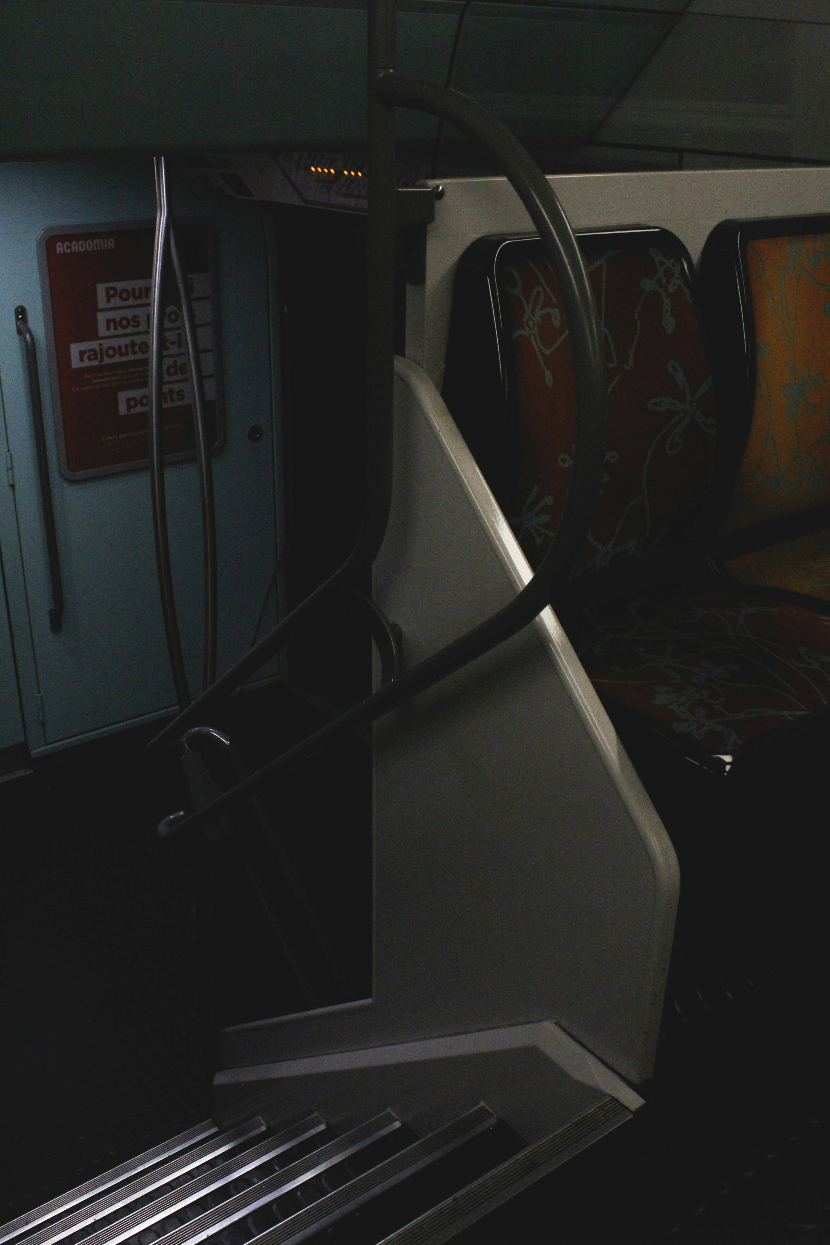 Curved Rails in the Dim Car: A Quiet Subway Interior