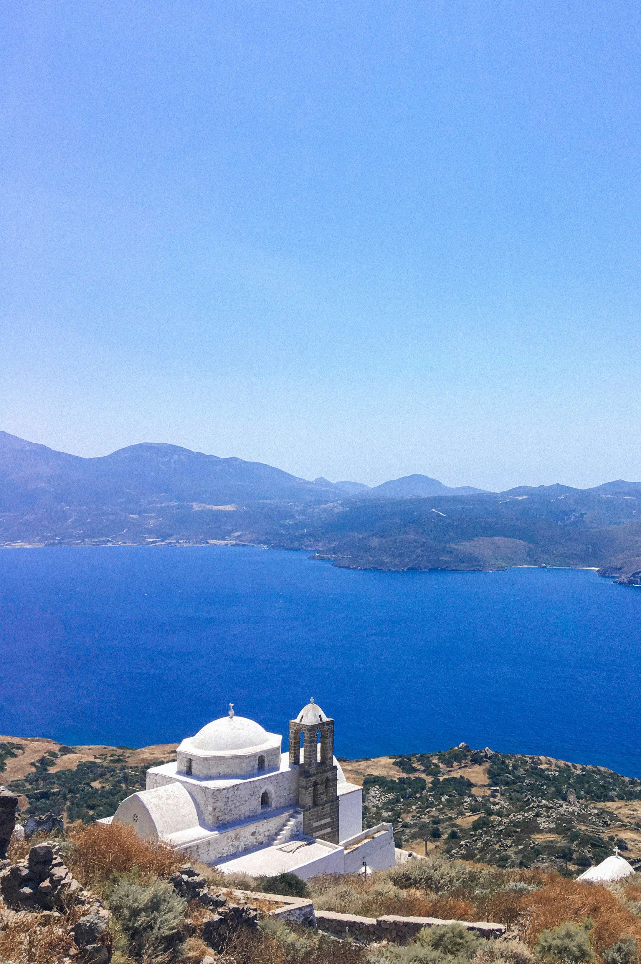 Cliffside White Chapel Over a Cobalt Aegean