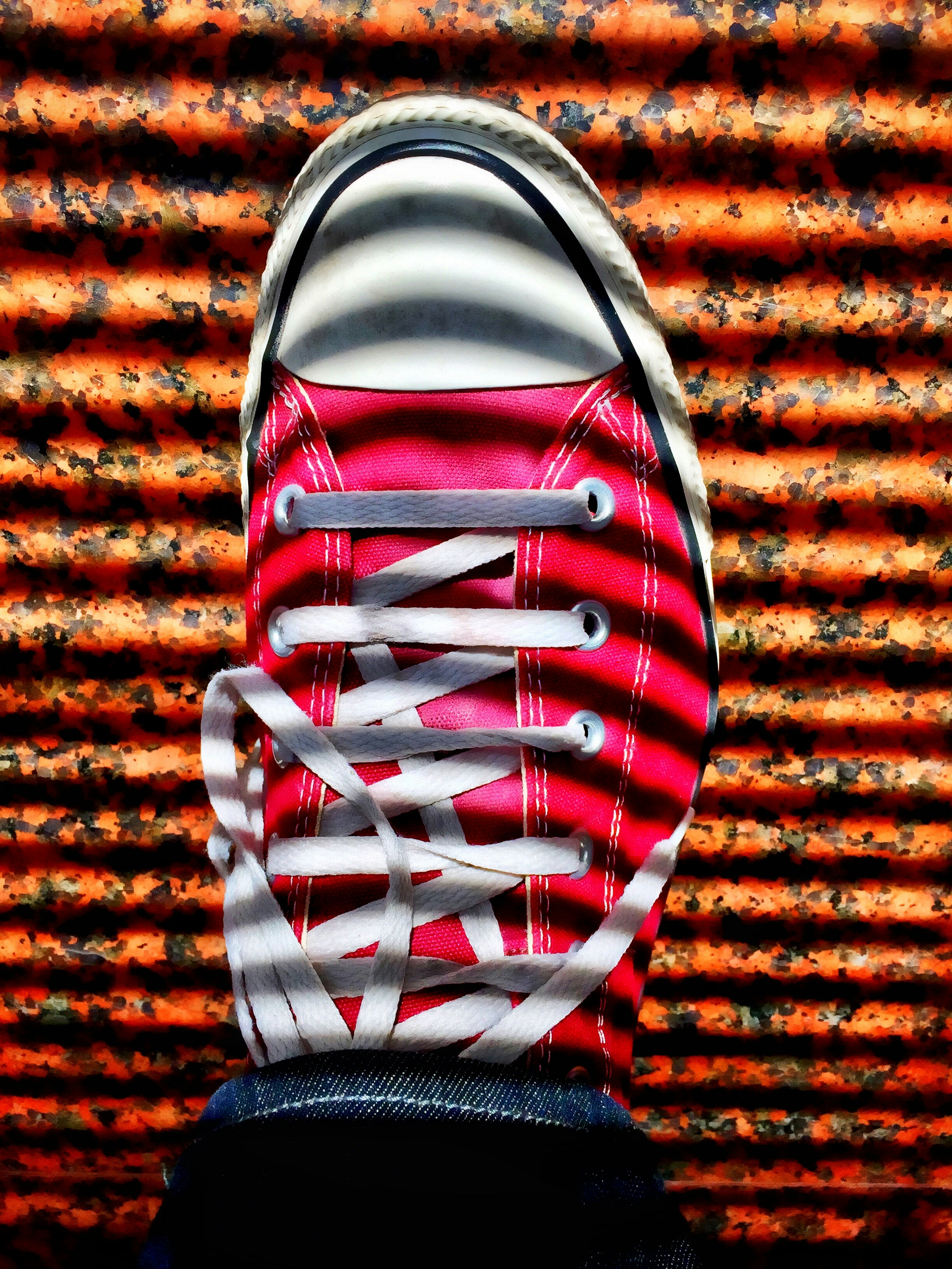 Crimson Converse on a Rust-Striped Canvas