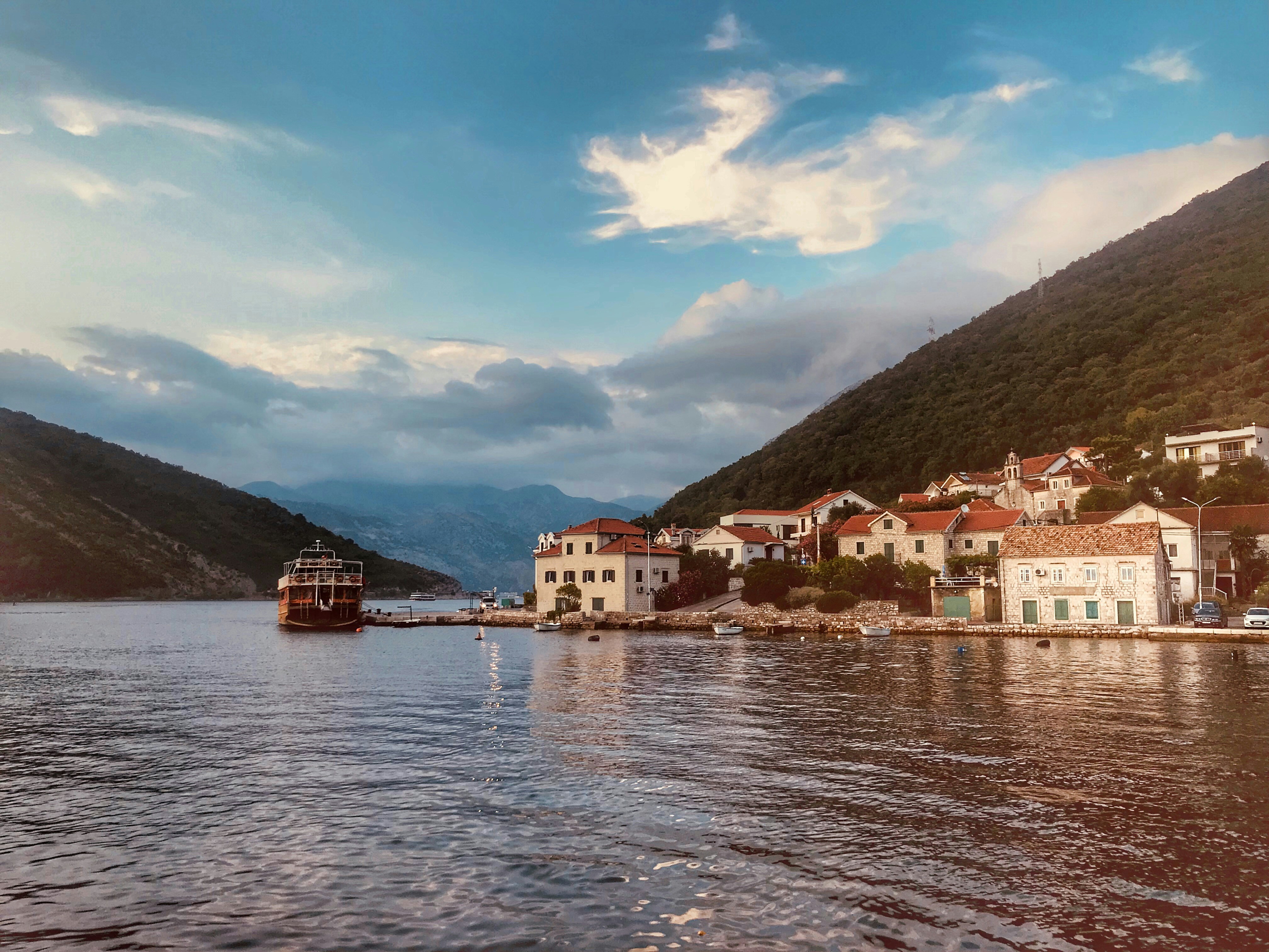 Pastel Harbor Village: Hills, Boats, and a Calm Bay