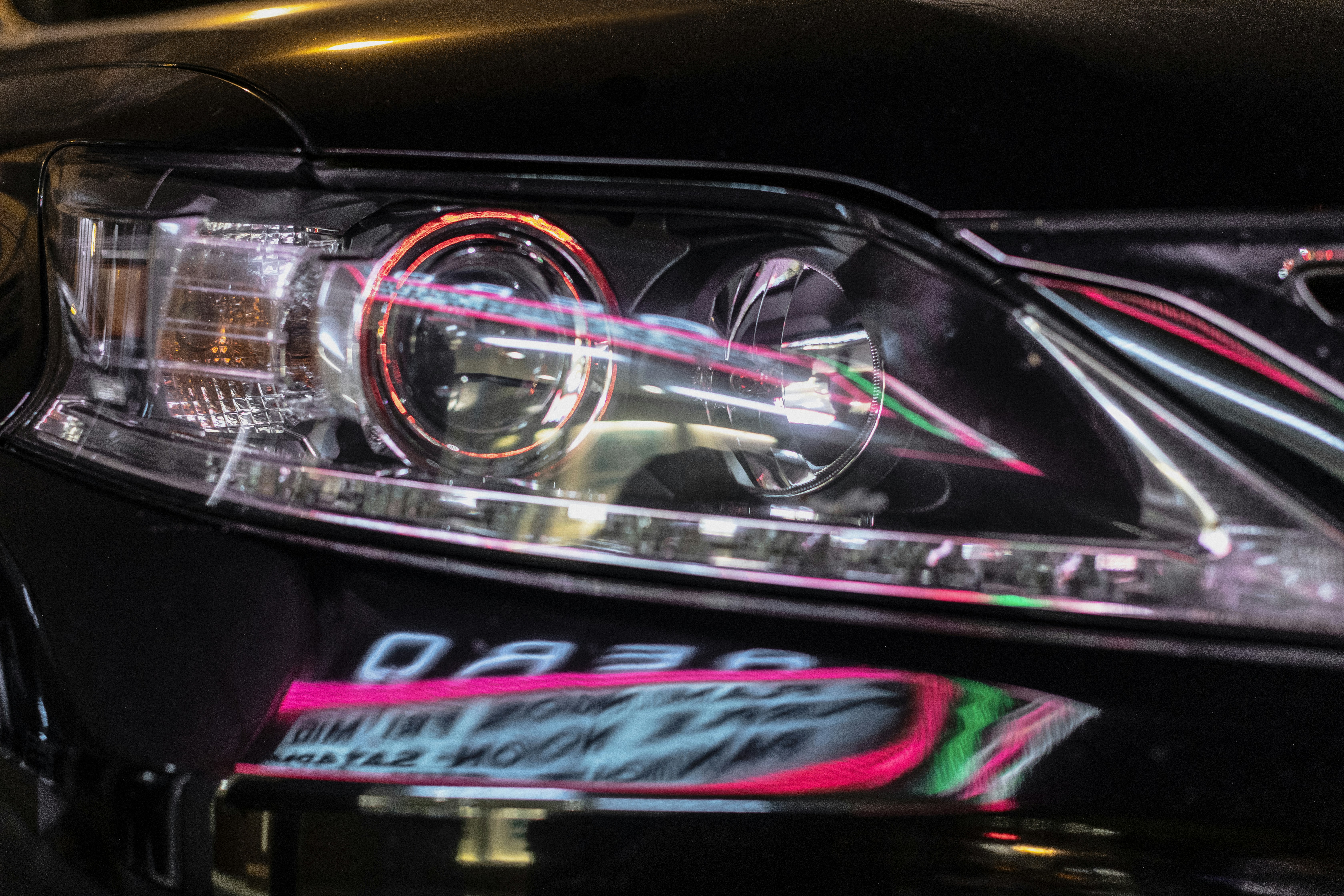 Red-ring projector in neon-lit headlamp: a close-up of motion-lit chromatics