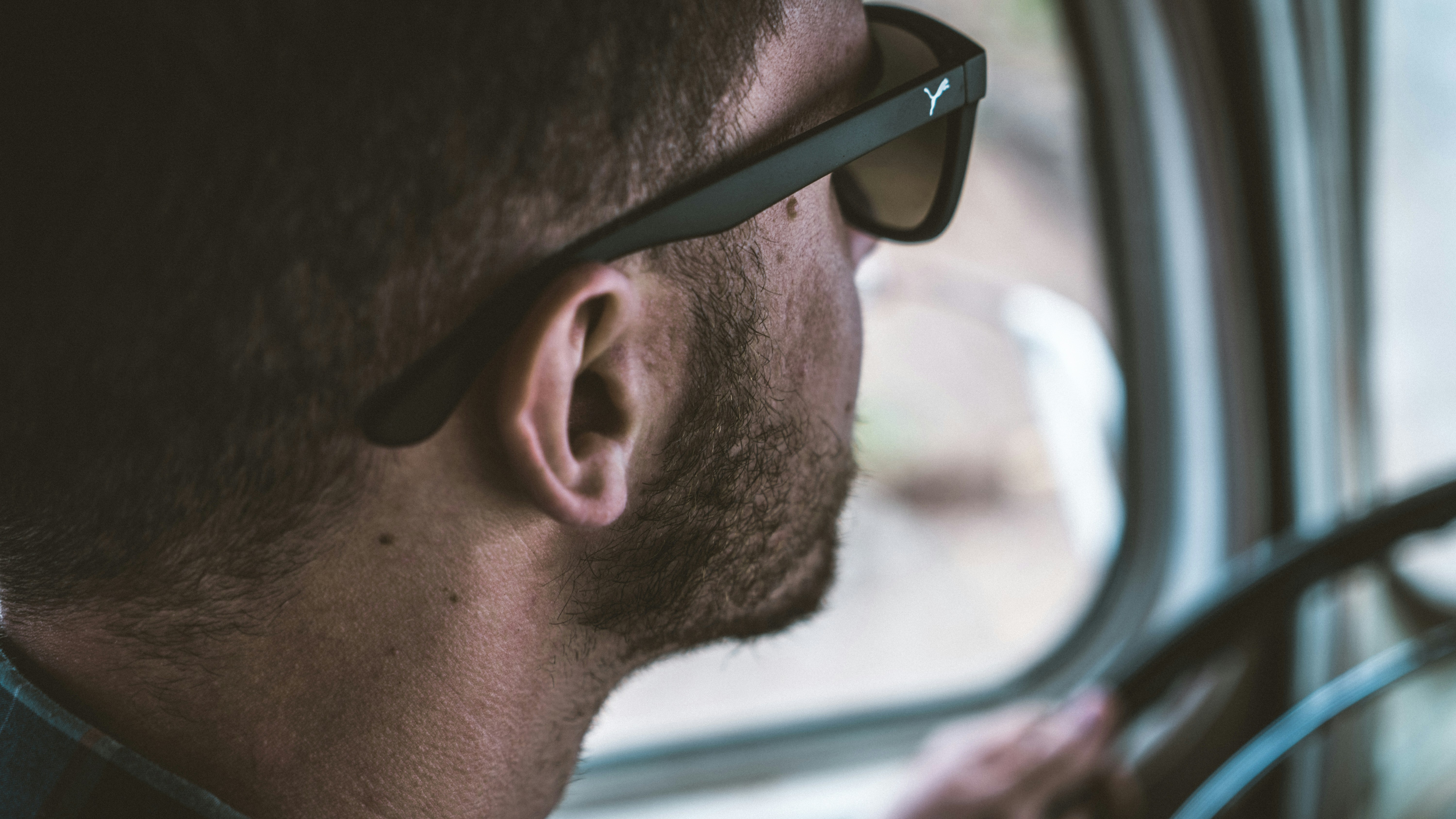 Side Profile in Transit: Sunglasses, Glass, and the Quiet Drive