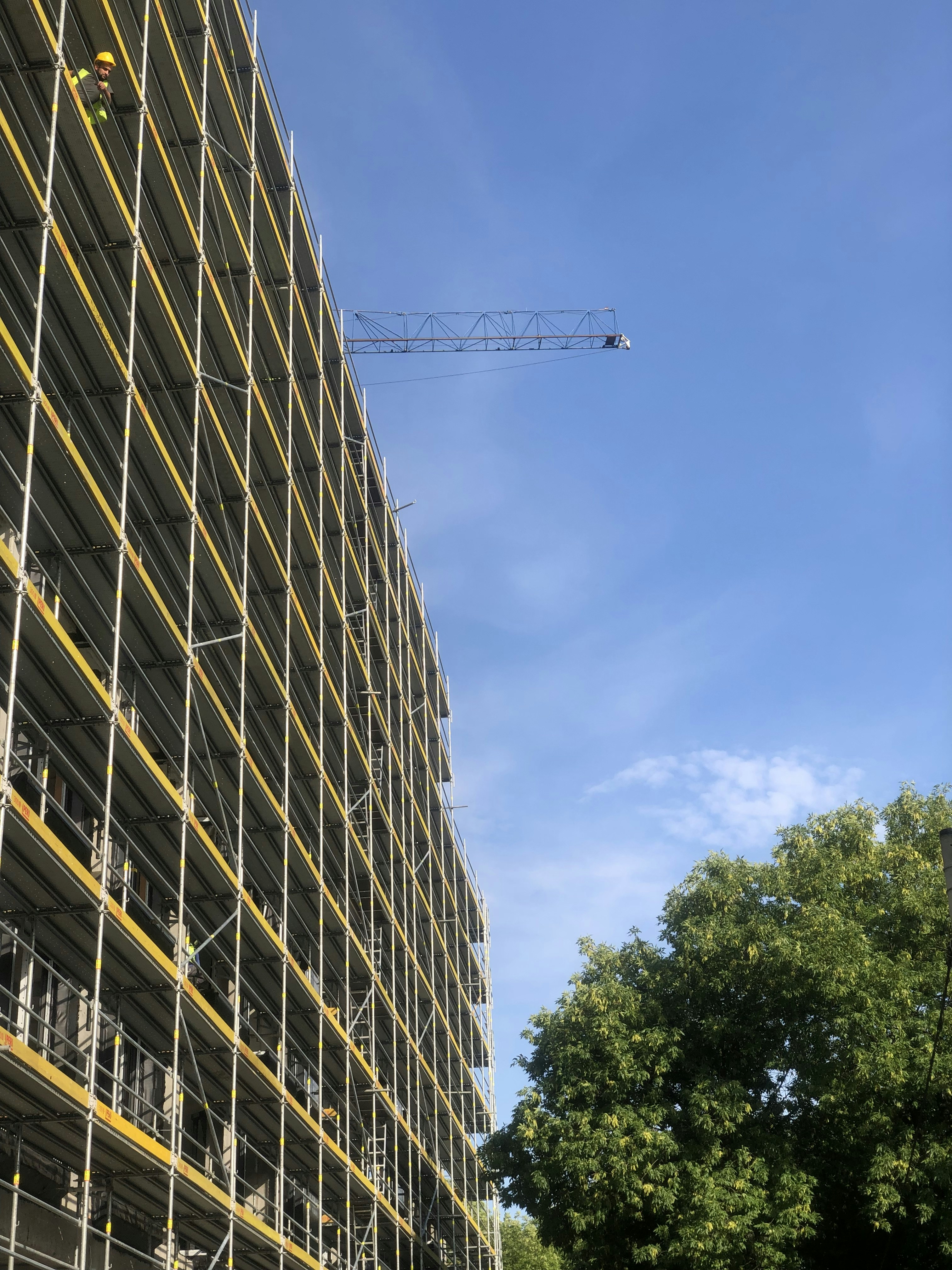 Crane Over Gridwork: Rising Lines Against a Blue Sky