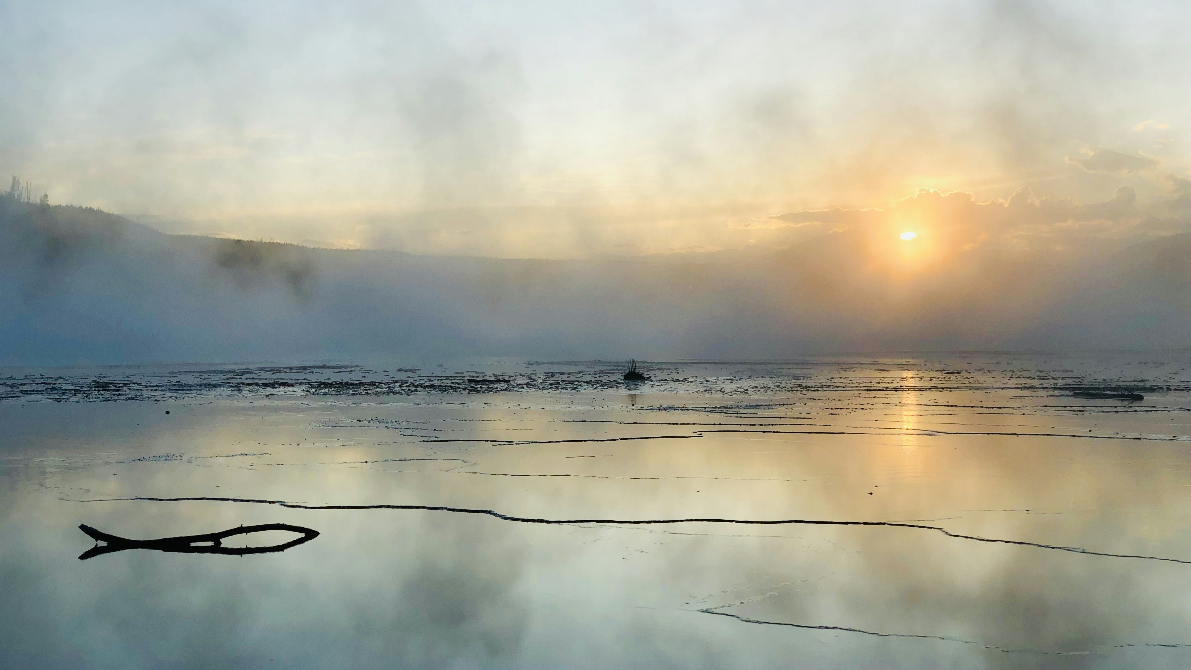 Dawn on a Steam-Wrapped Thermal Lake: Sun, Mist, and Mirror Water