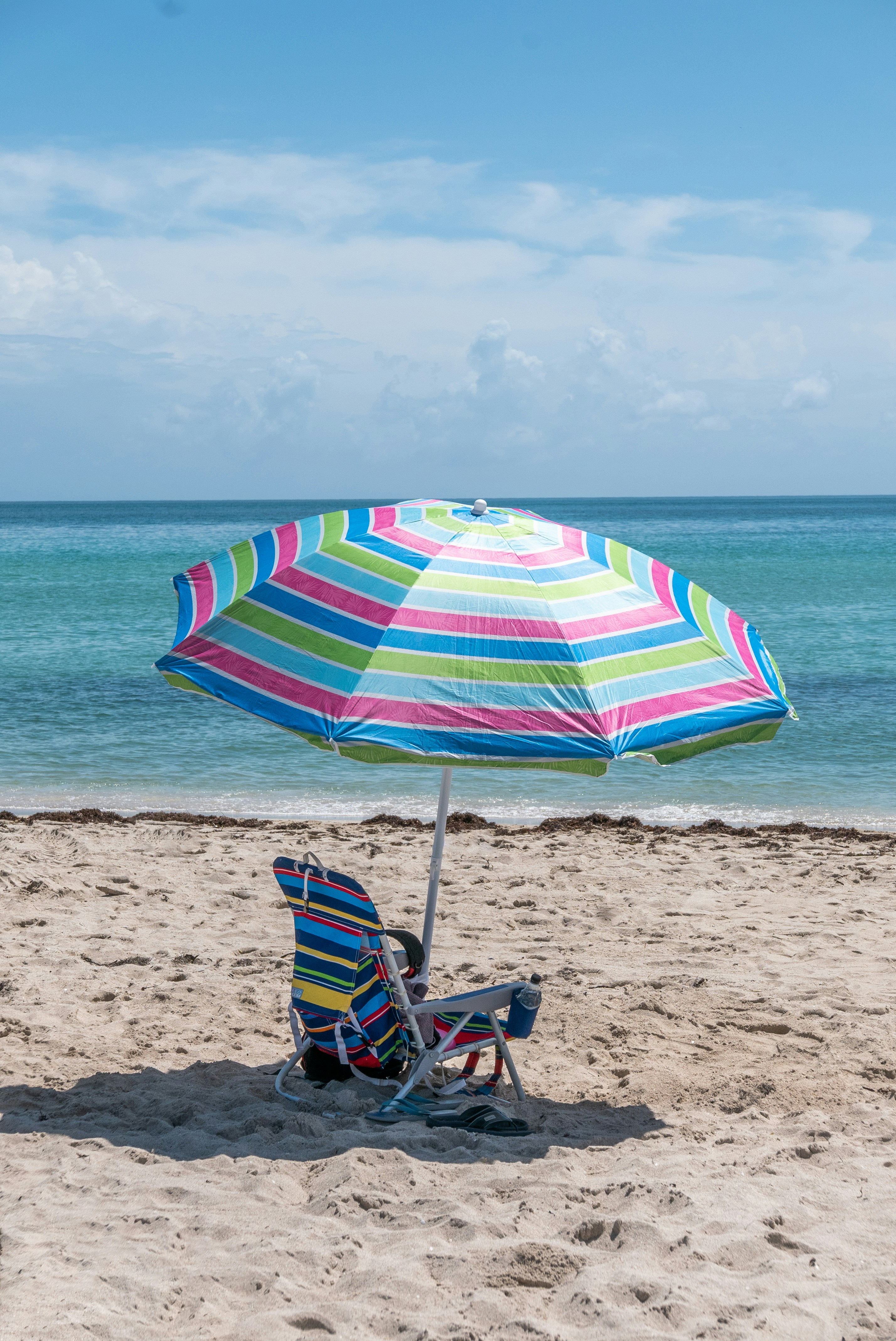 Striped parasol throne: a sunlit beach scene with a colorful umbrella