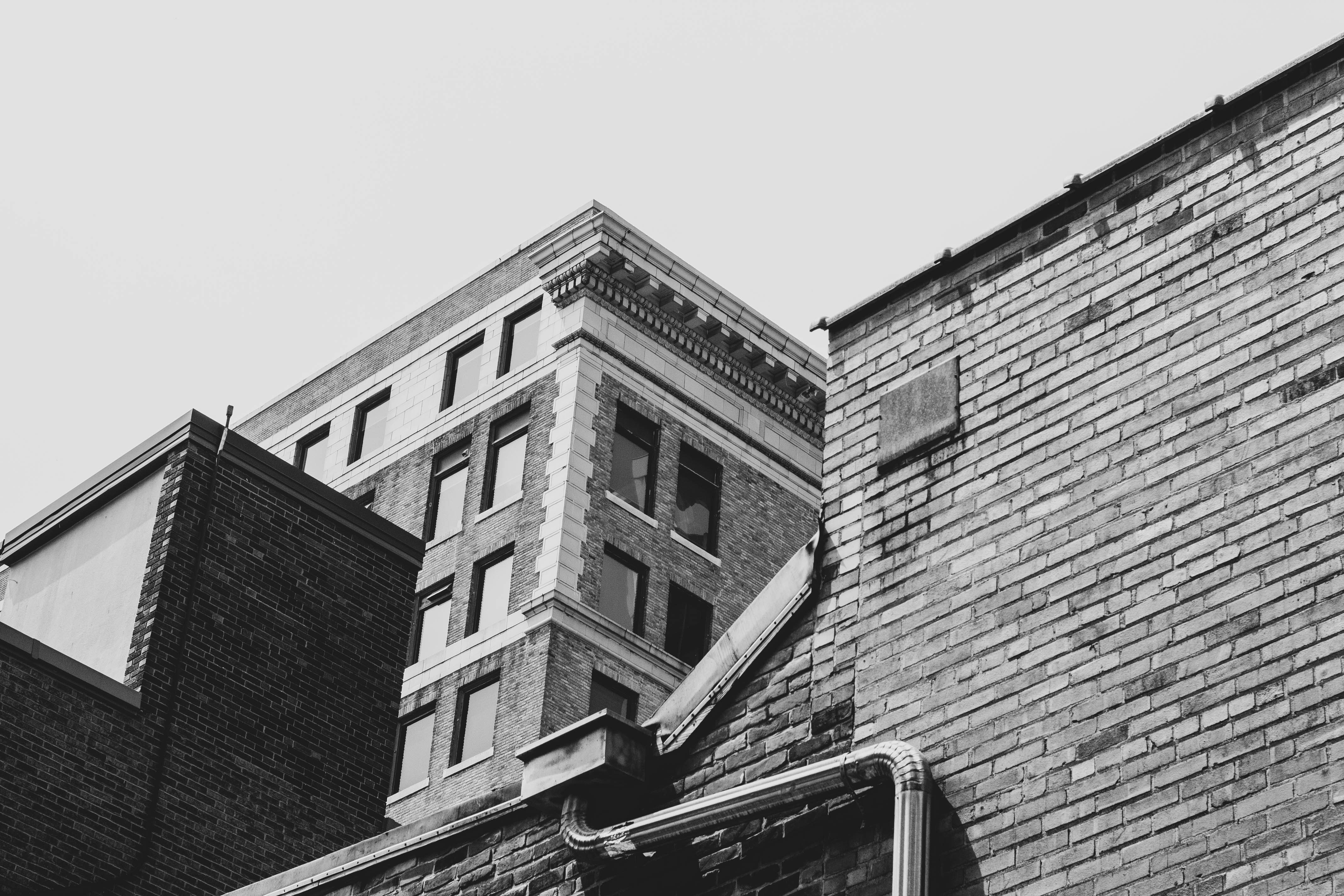 Grayscale photo of a multi-story concrete and brick building with angular lines.