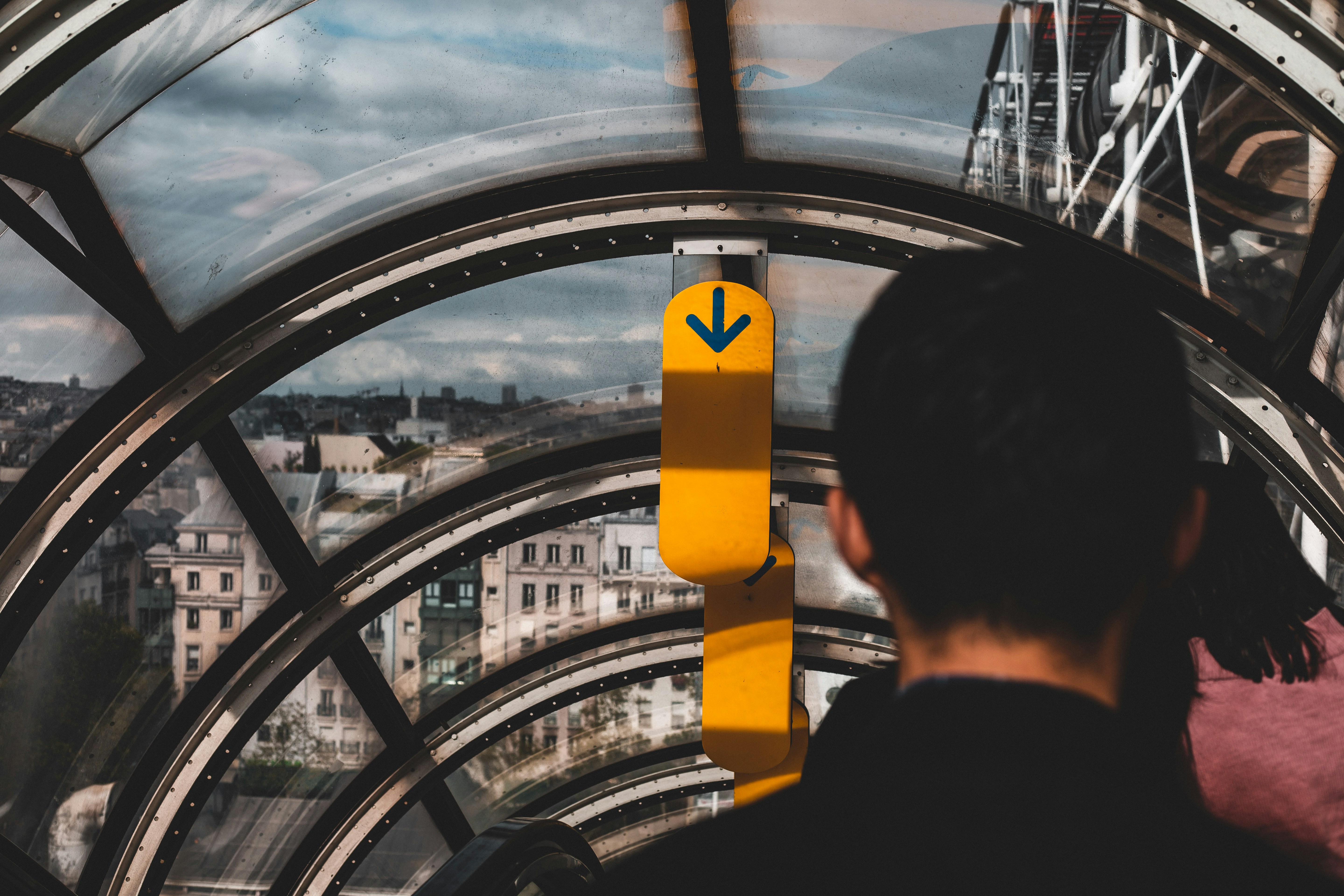 A person looking out a window at a city photo – Free Human Image on ...