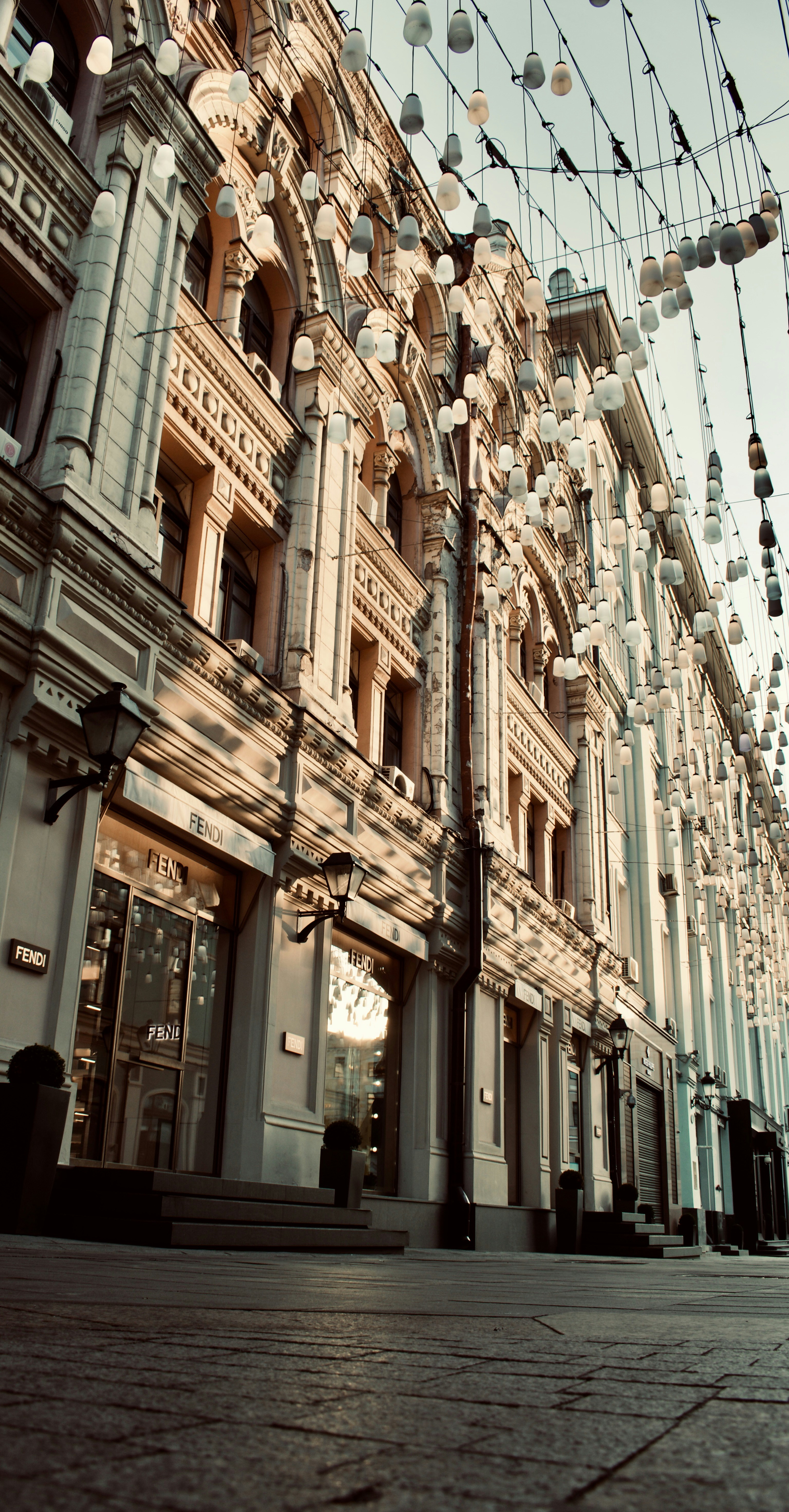 Historic architecture adorned with decorative lighting, showcasing the luxurious storefronts along a bustling street.