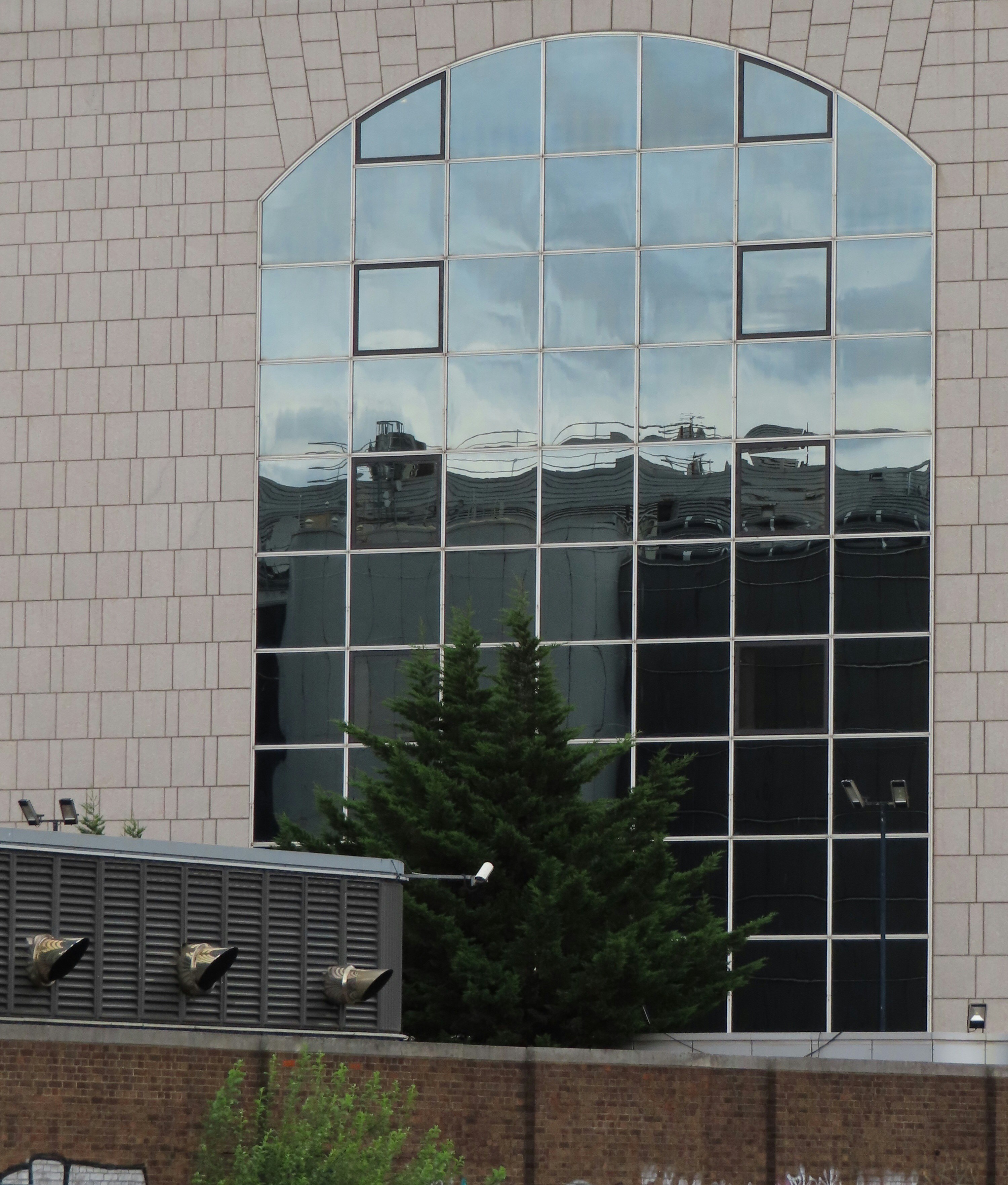 Arched Facade Reflections over a Treeline