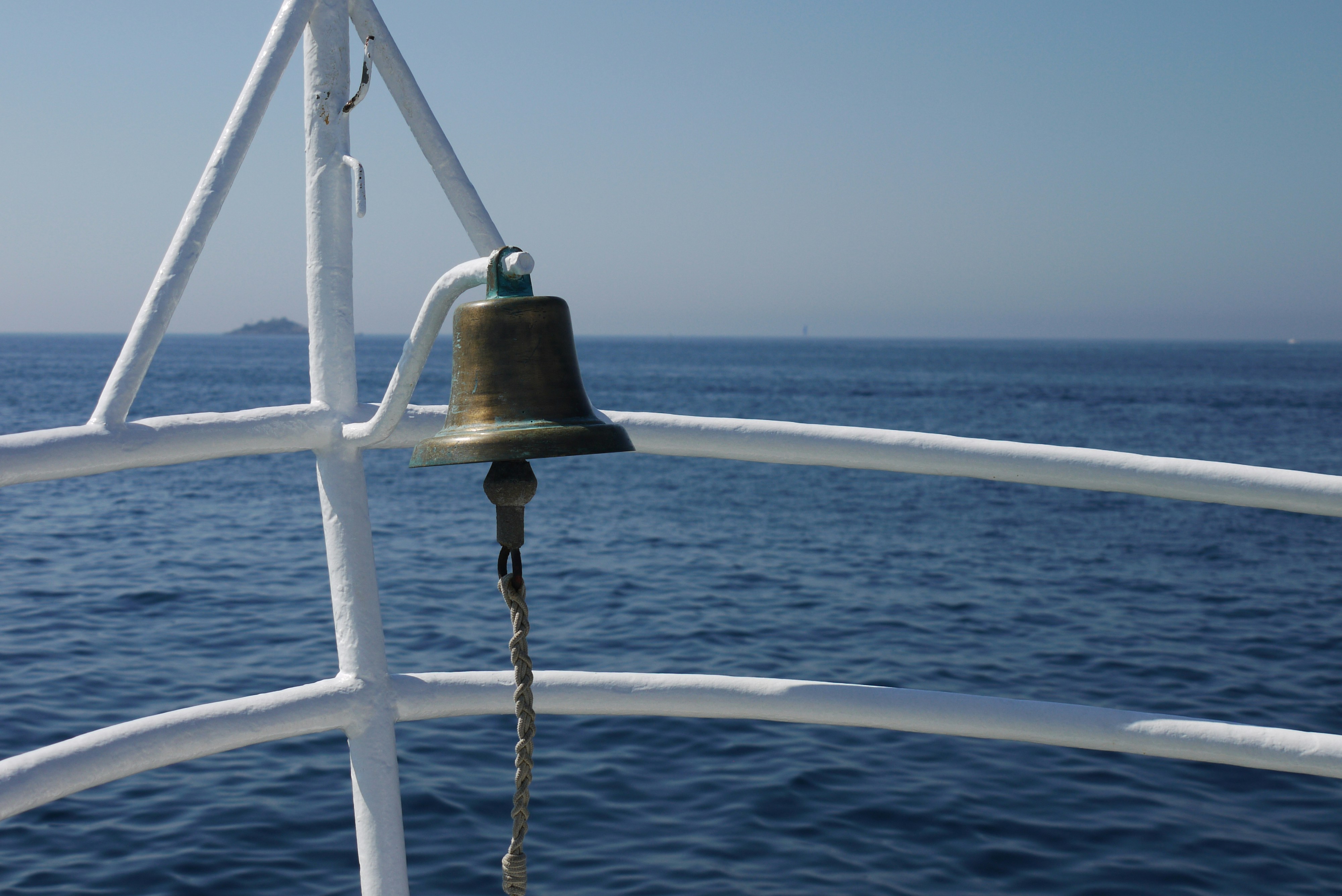 Bell on the Rail: Quiet Horizon over a Blue Sea