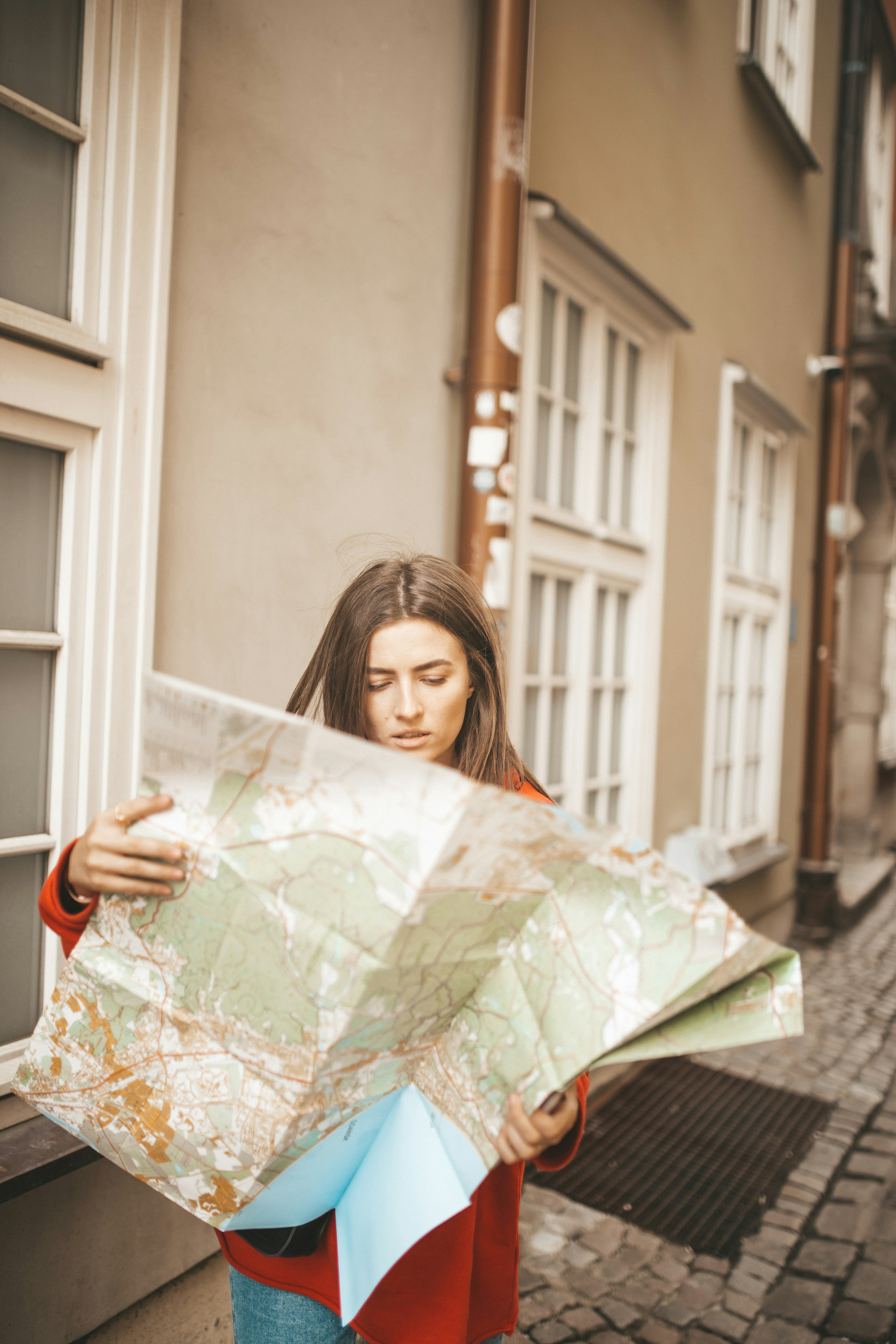 Cartography in a Cobblestone Lane: A Woman Navigates with a Map