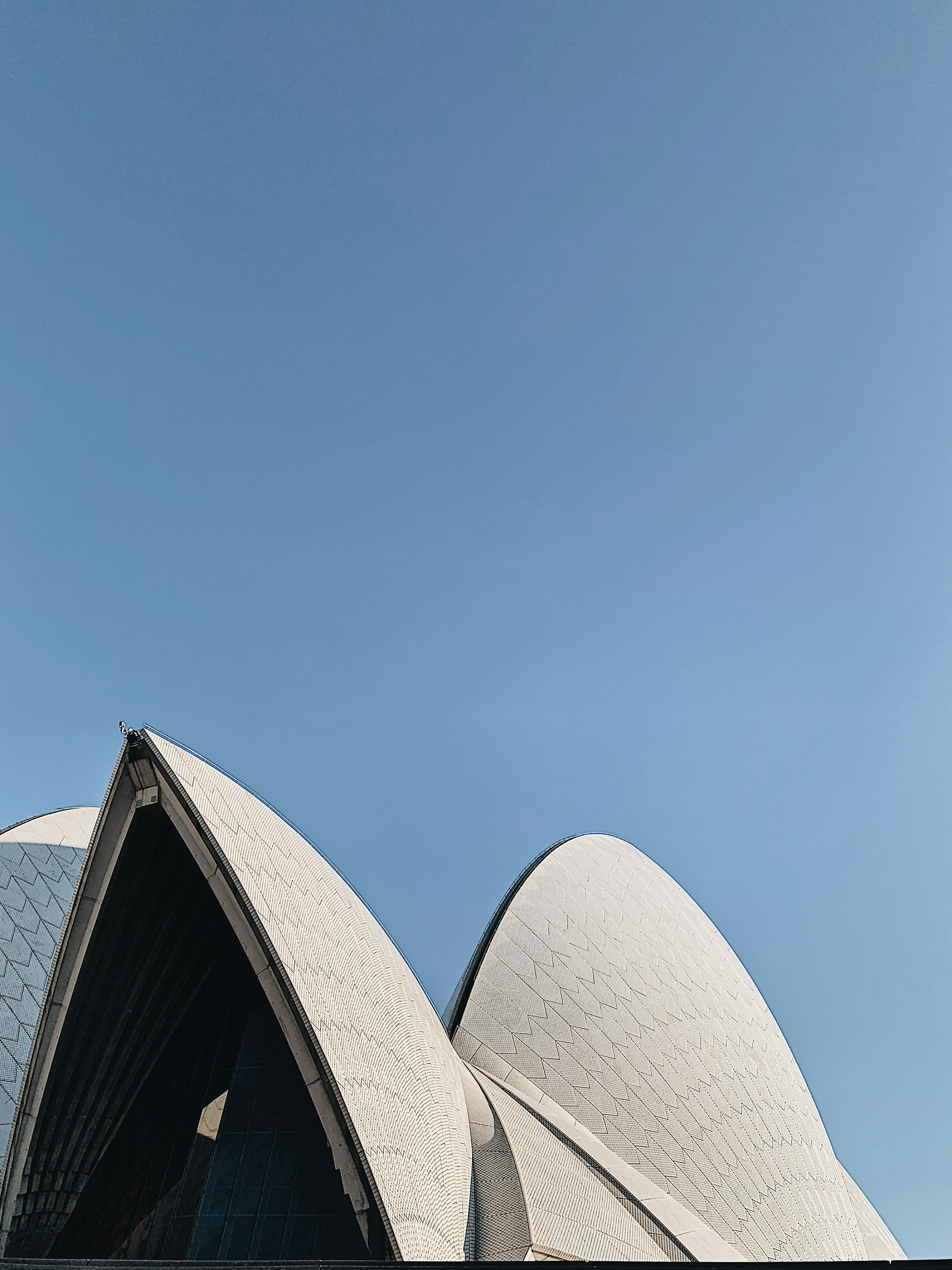 Iconic architectural design of the Sydney Opera House against a vibrant blue sky.