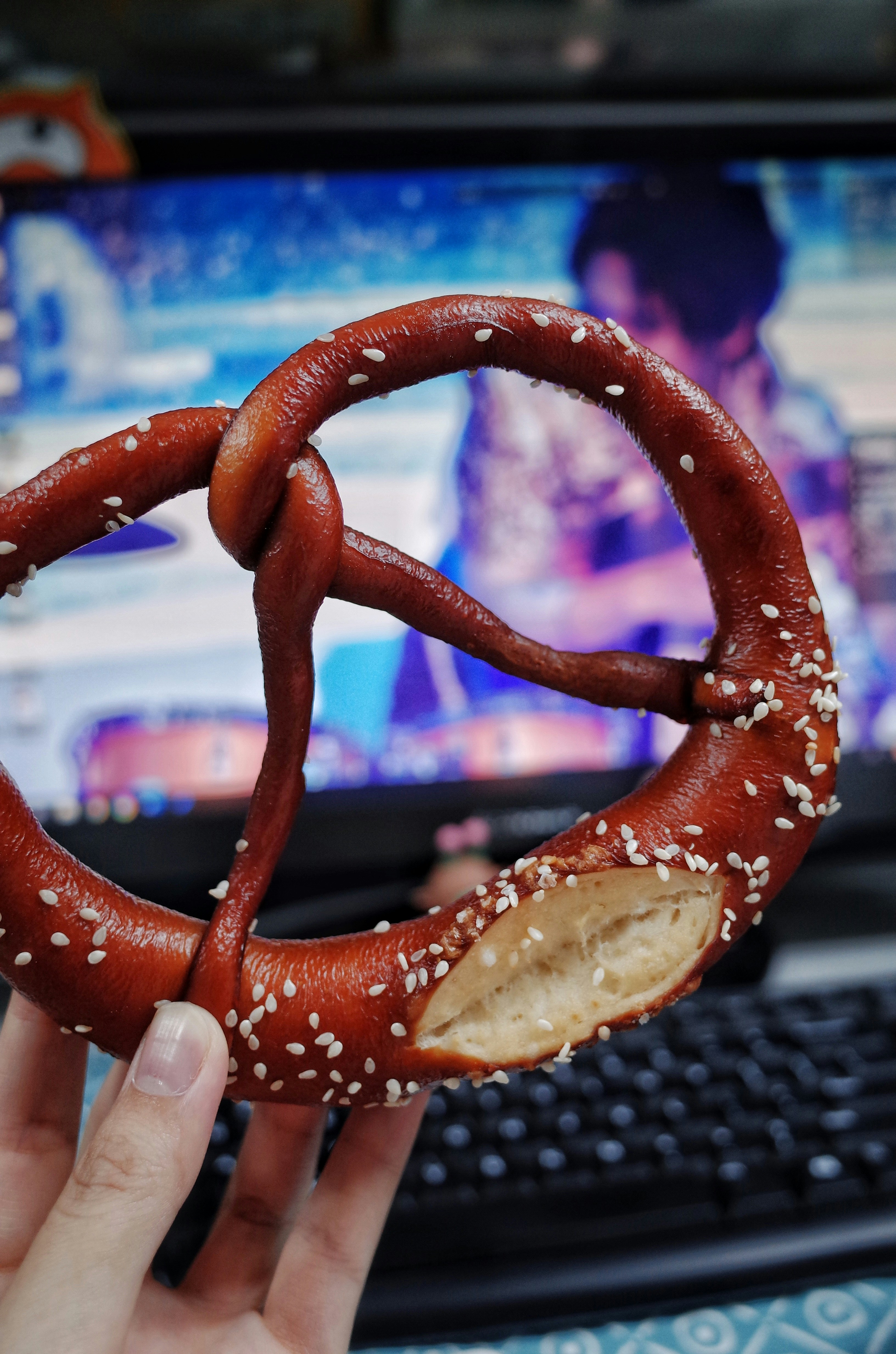 Sesame-Studded Pretzel Ring in Sharp Focus Before a Blurred Poolside Laptop