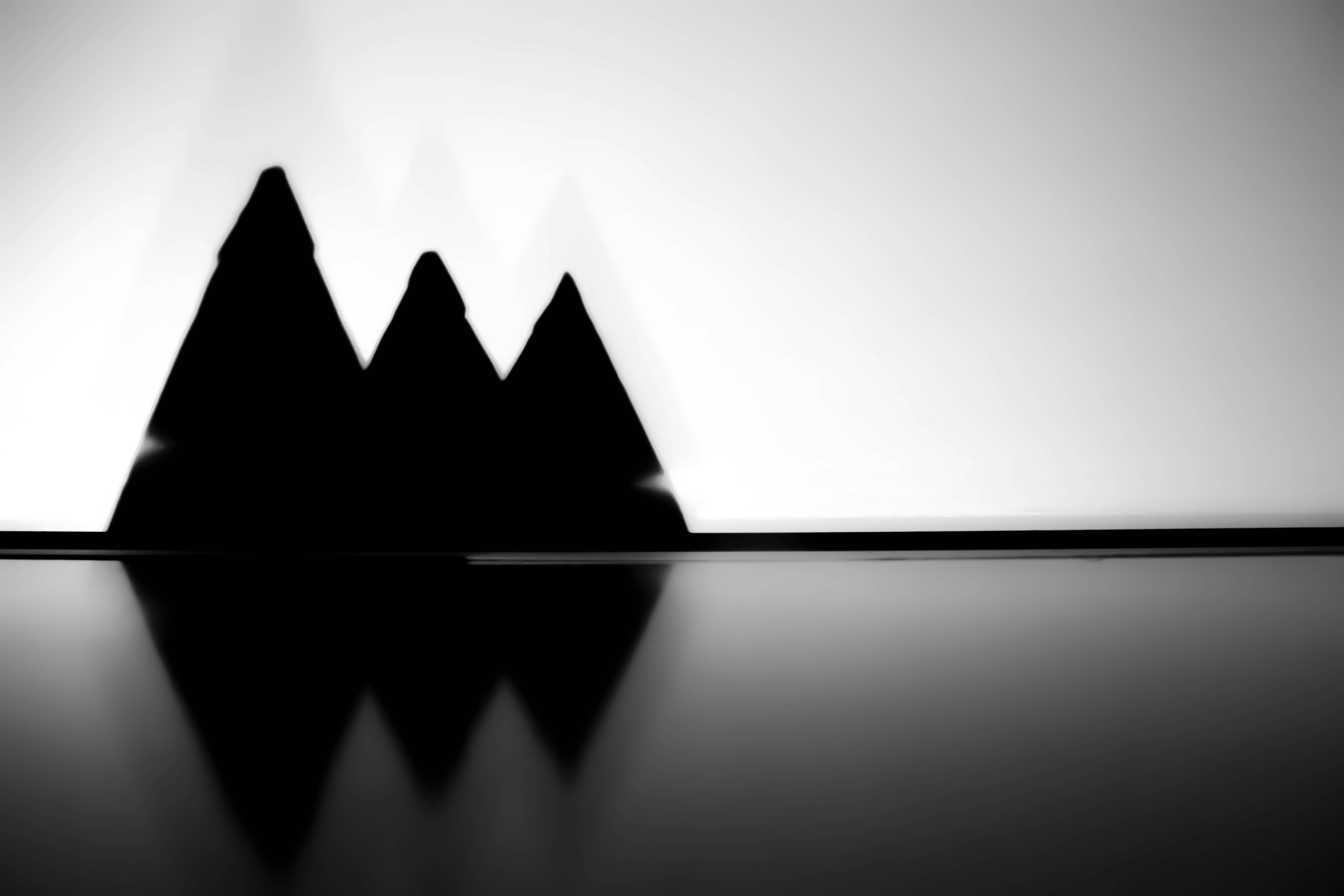 Minimalist Triad: Black Peaks and Their Reflective Shore