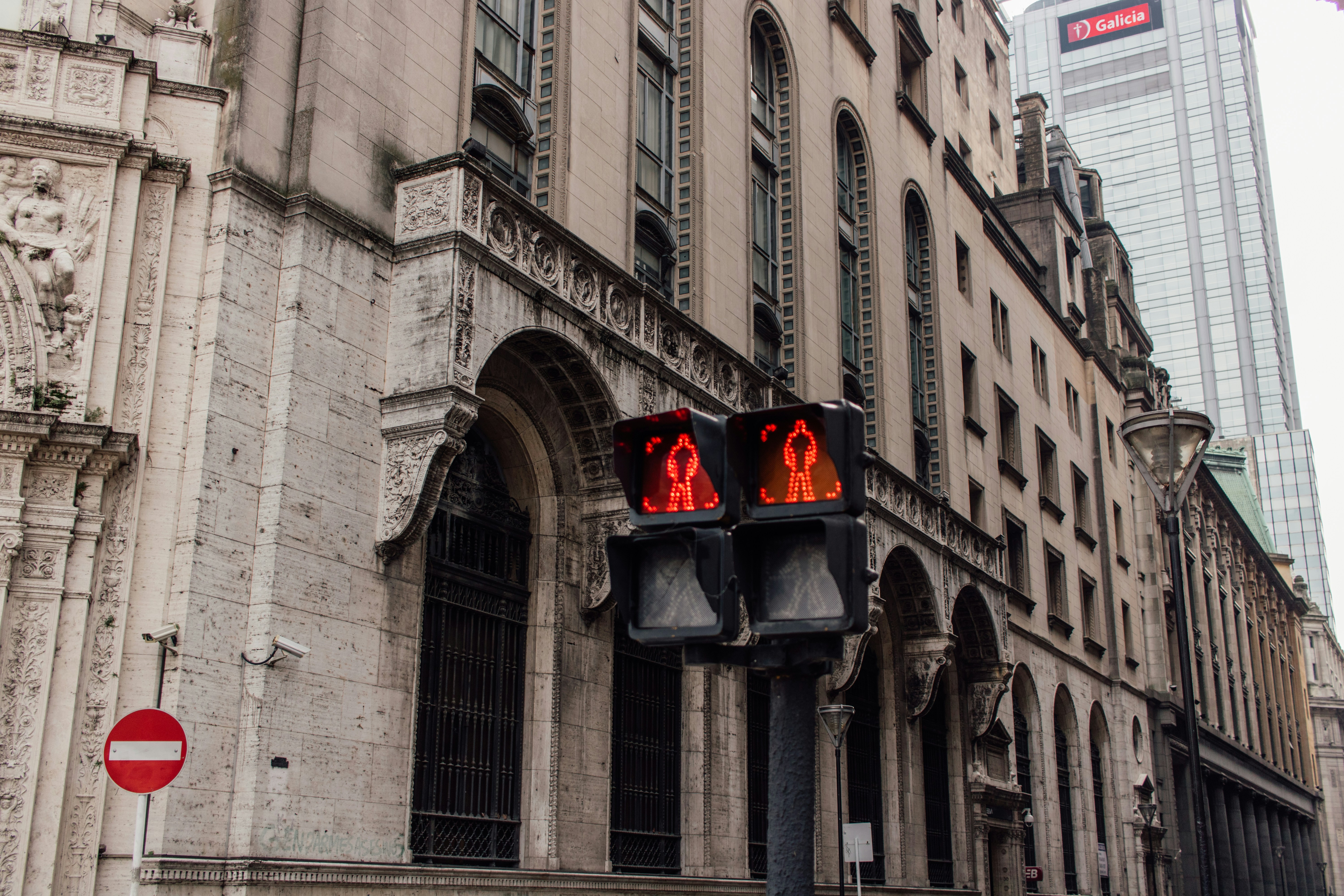Red Pedestrian Signals Stood Guard Before Historic Stone Facades