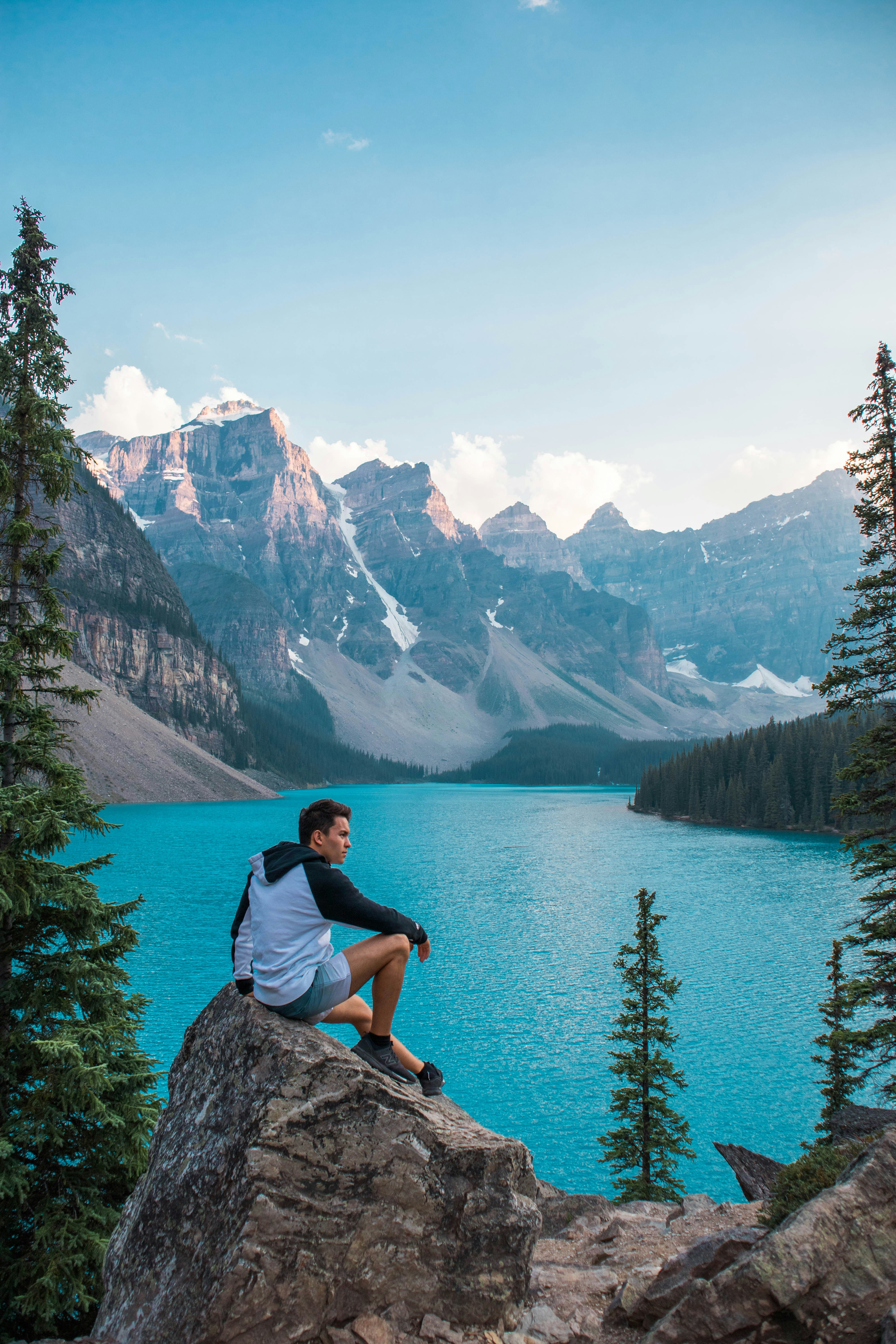 Azure Silence: Man Perched Above a Turquoise Alpine Lake