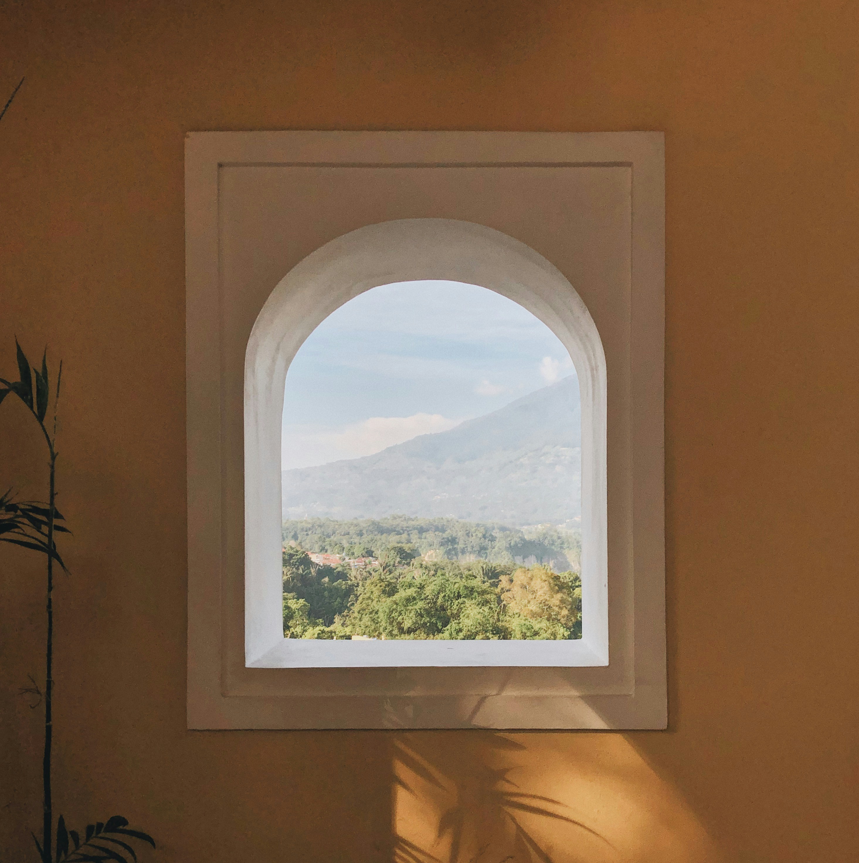 Archway Vista: Mountain Range Through a Sunlit Interior Window
