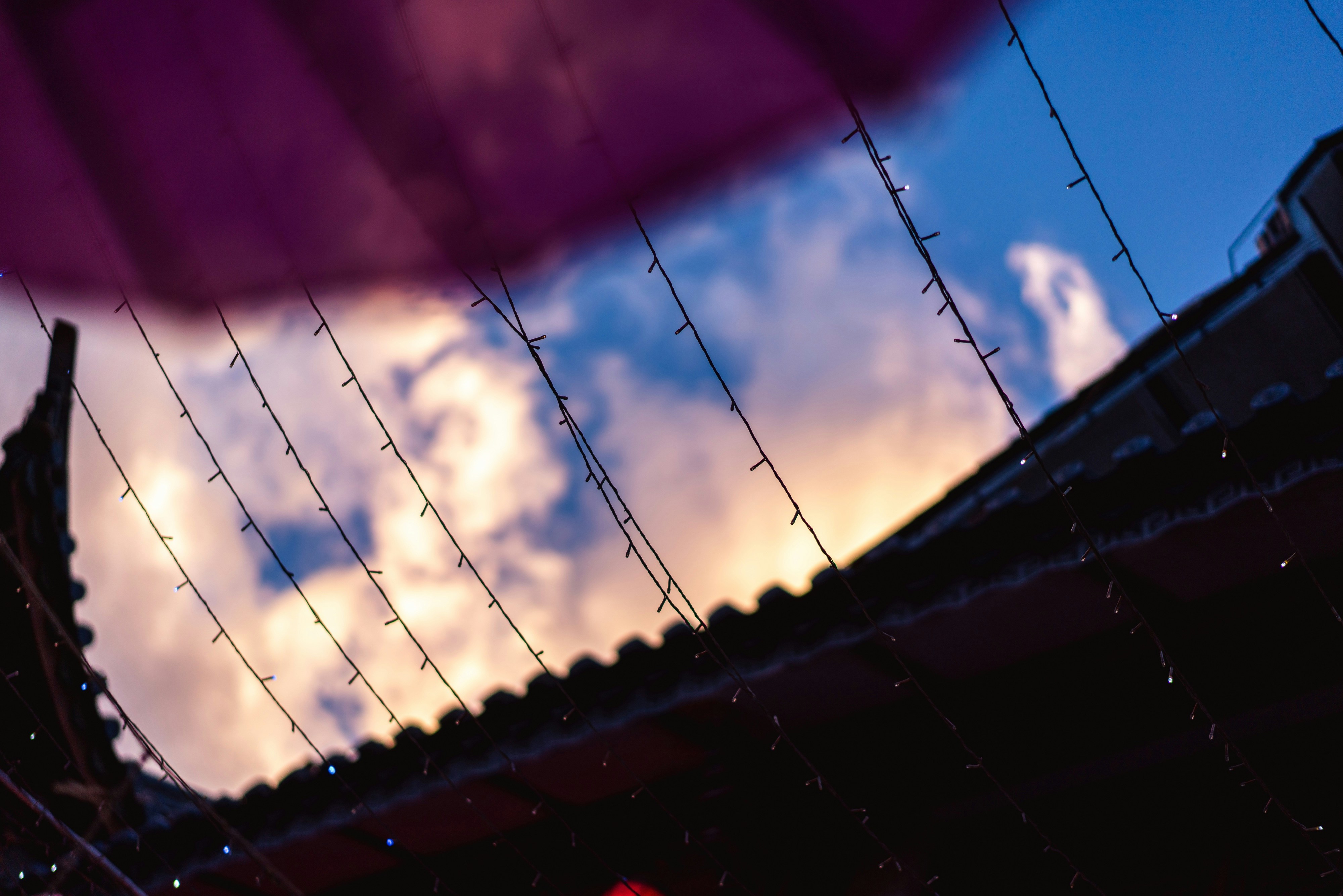 Barbed Sky: A Sunset Bokeh Behind Coiled Barbed Wire