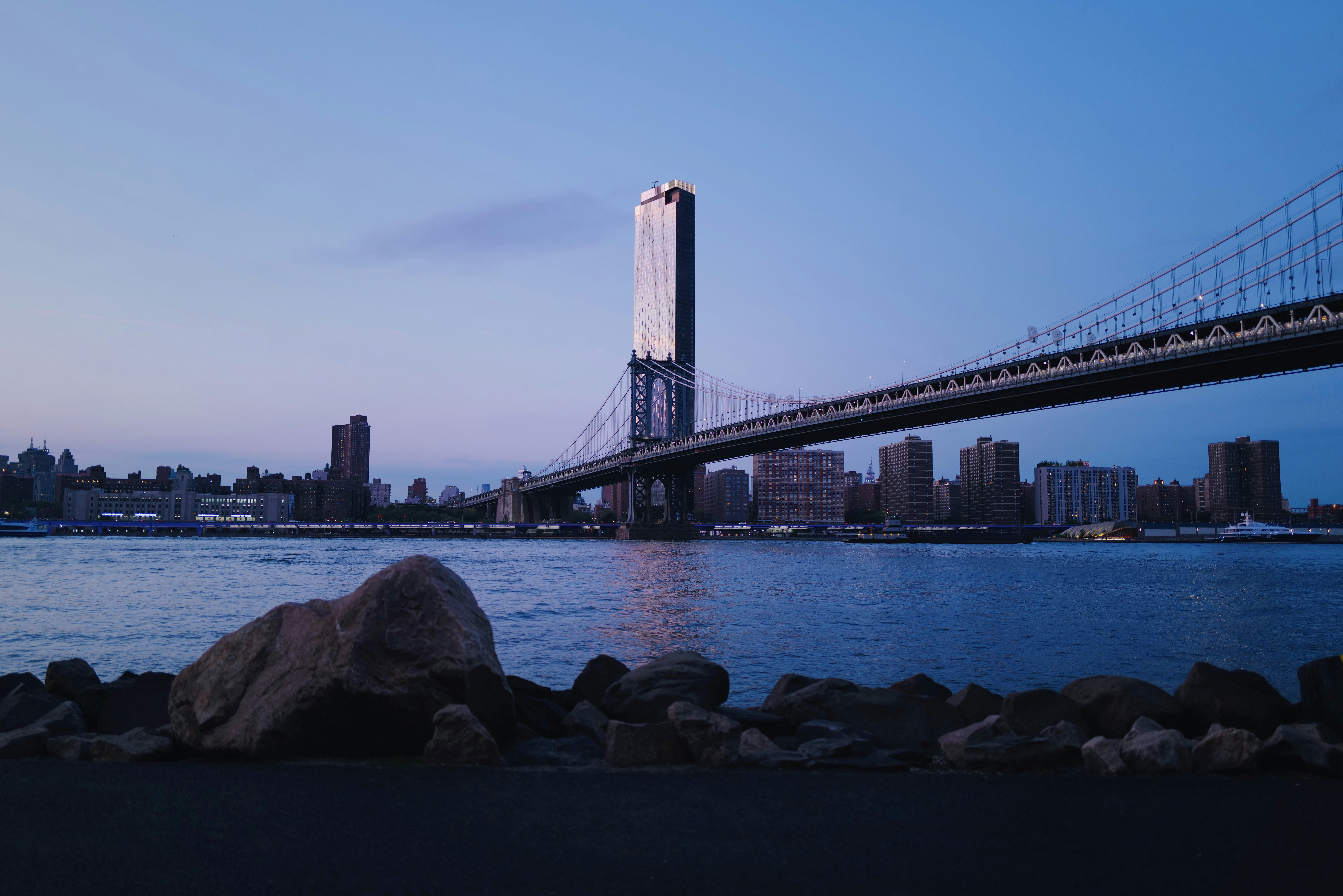 Twilight Pylon Over a Quiet River: A Long Suspension Bridge at Dusk