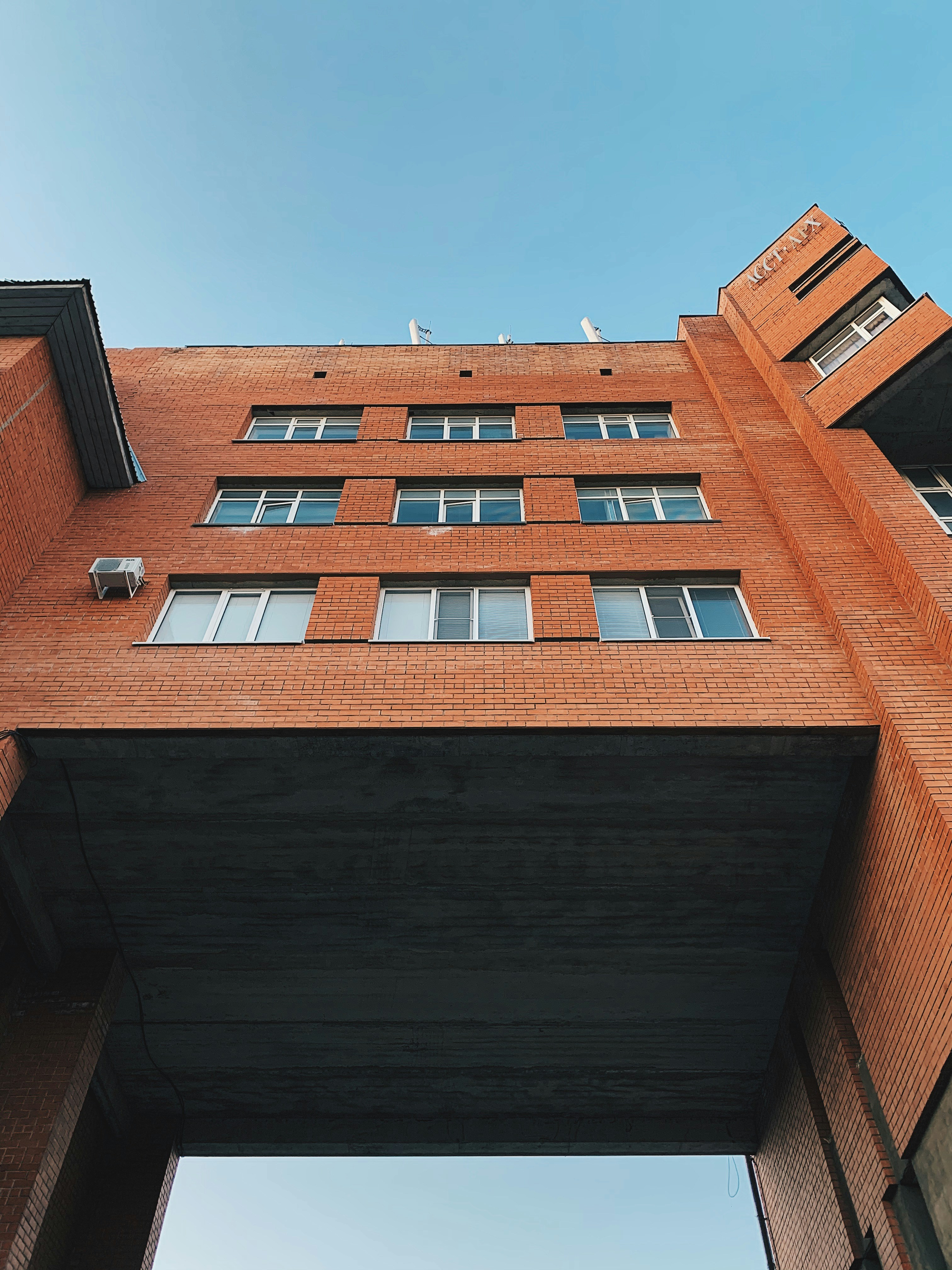 A tall red brick building with lots of windows photo – Free Blue Image ...