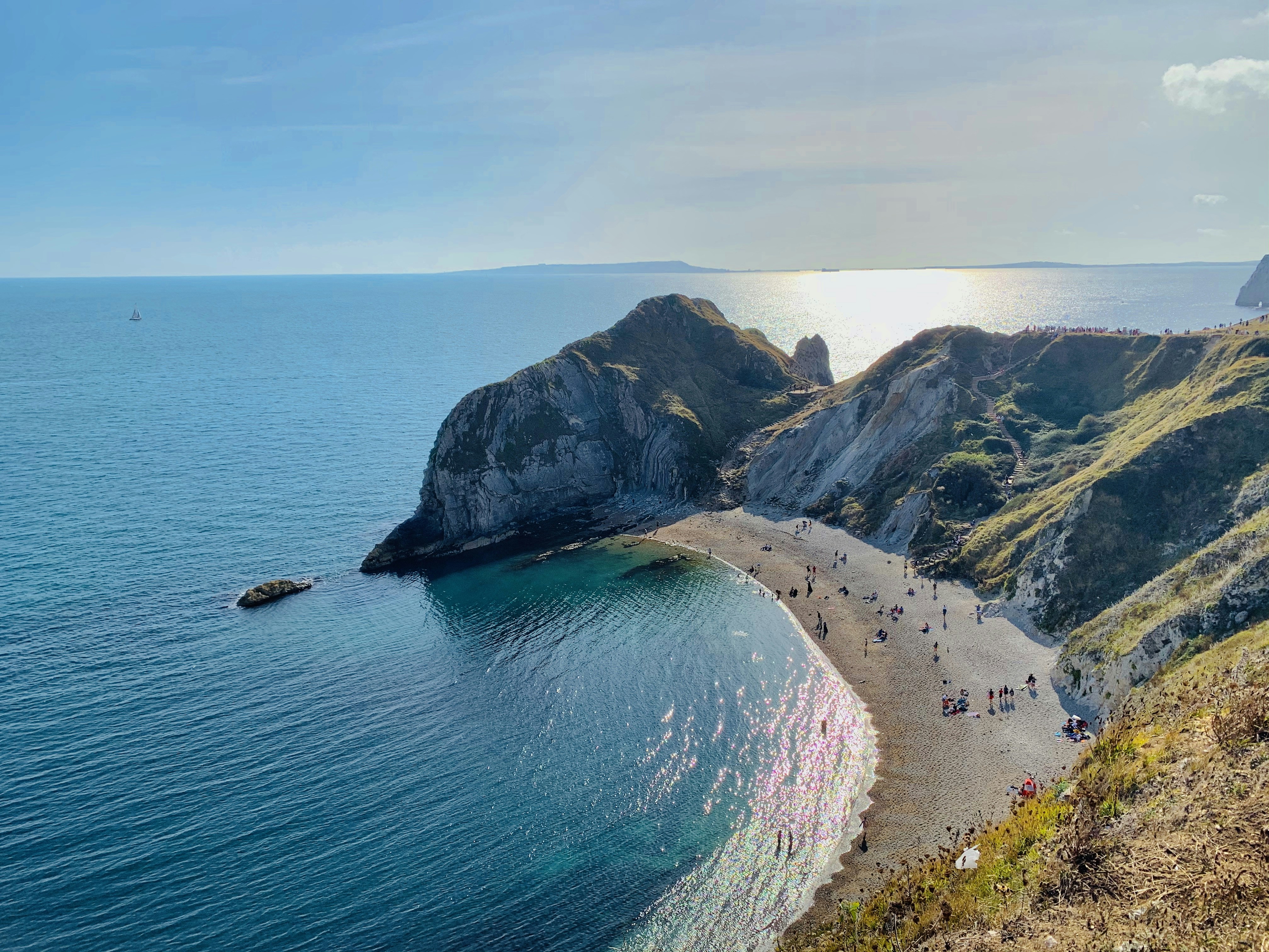 Crescent Cove: Sunlit Beach Between Weathered Cliffs