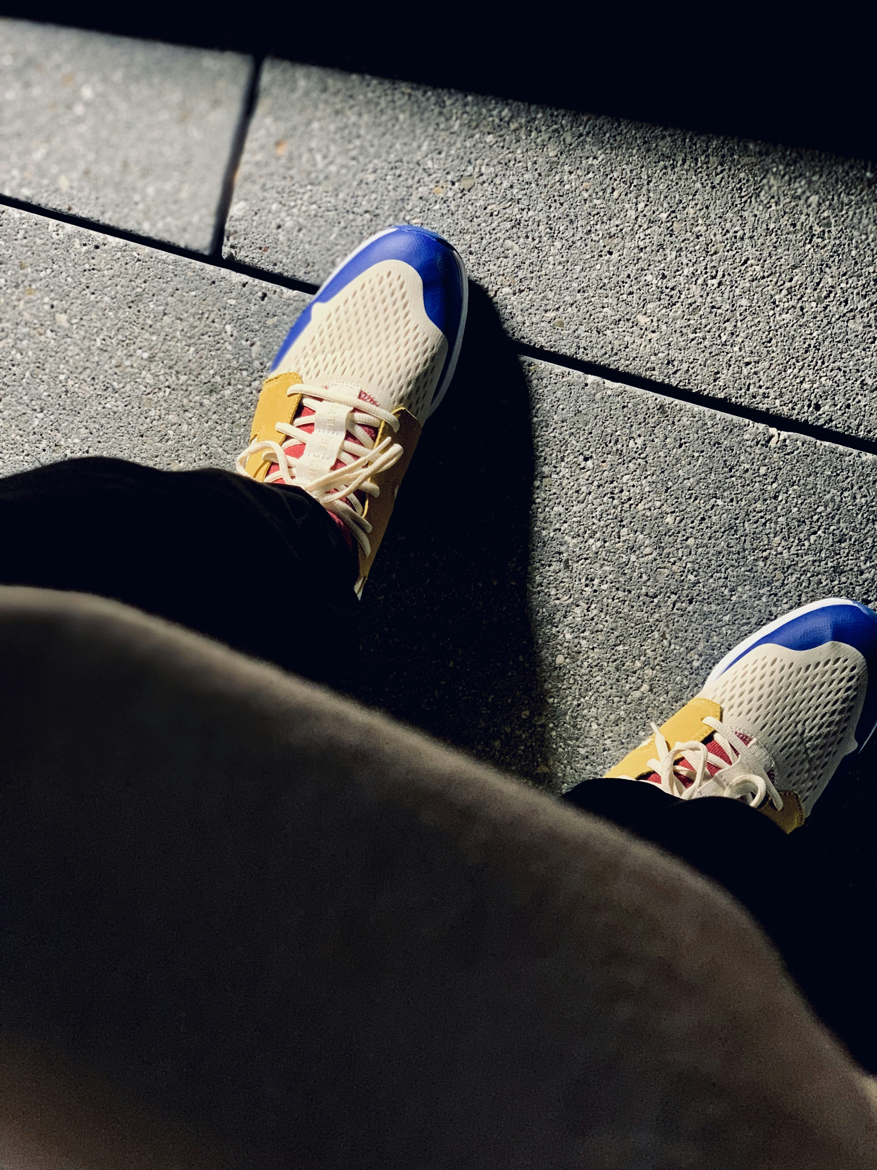 Colorful sneakers resting on a textured pavement, showcasing a blend of style and urban life.