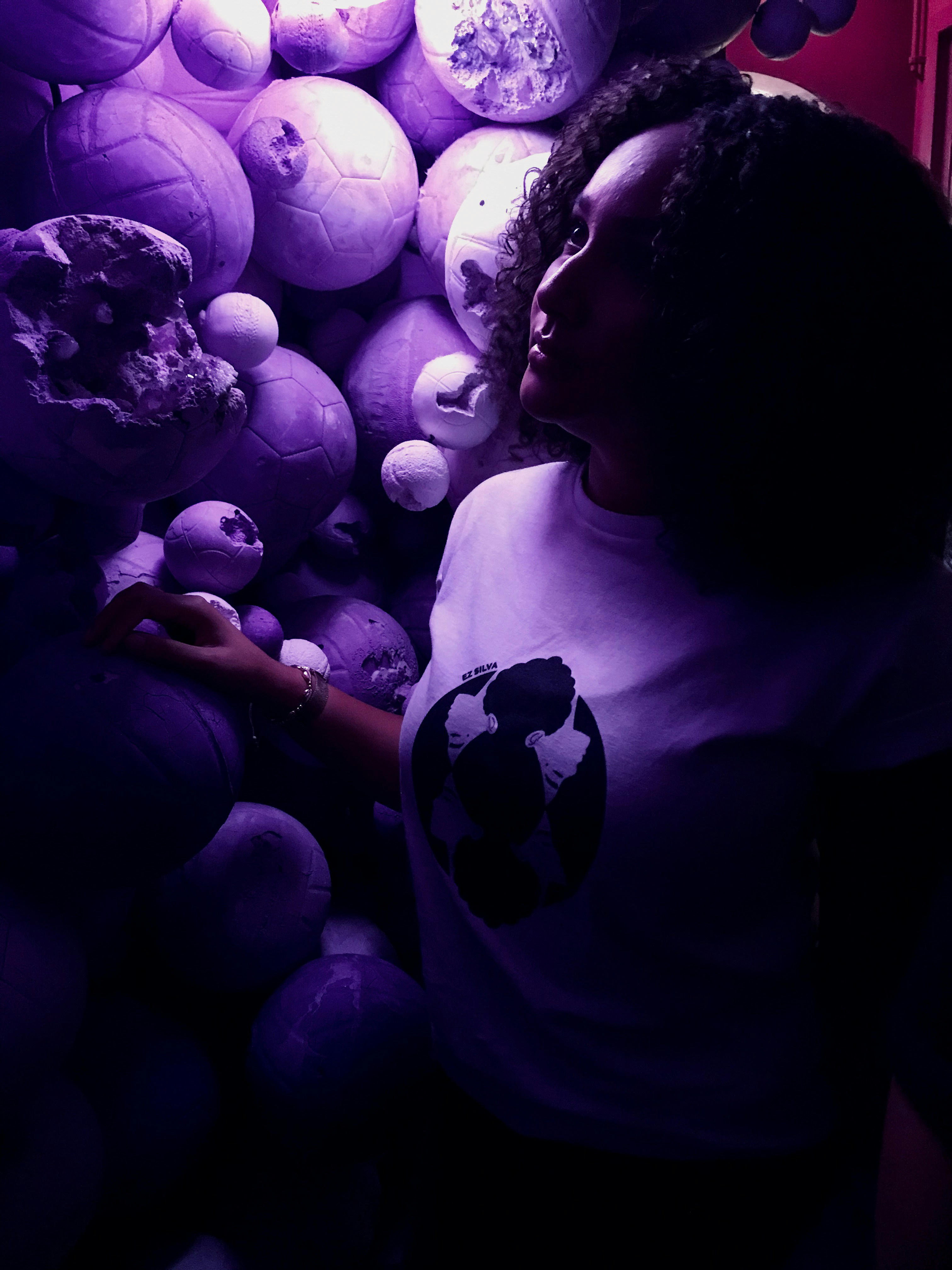 a woman standing in front of a pile of stuffed animals