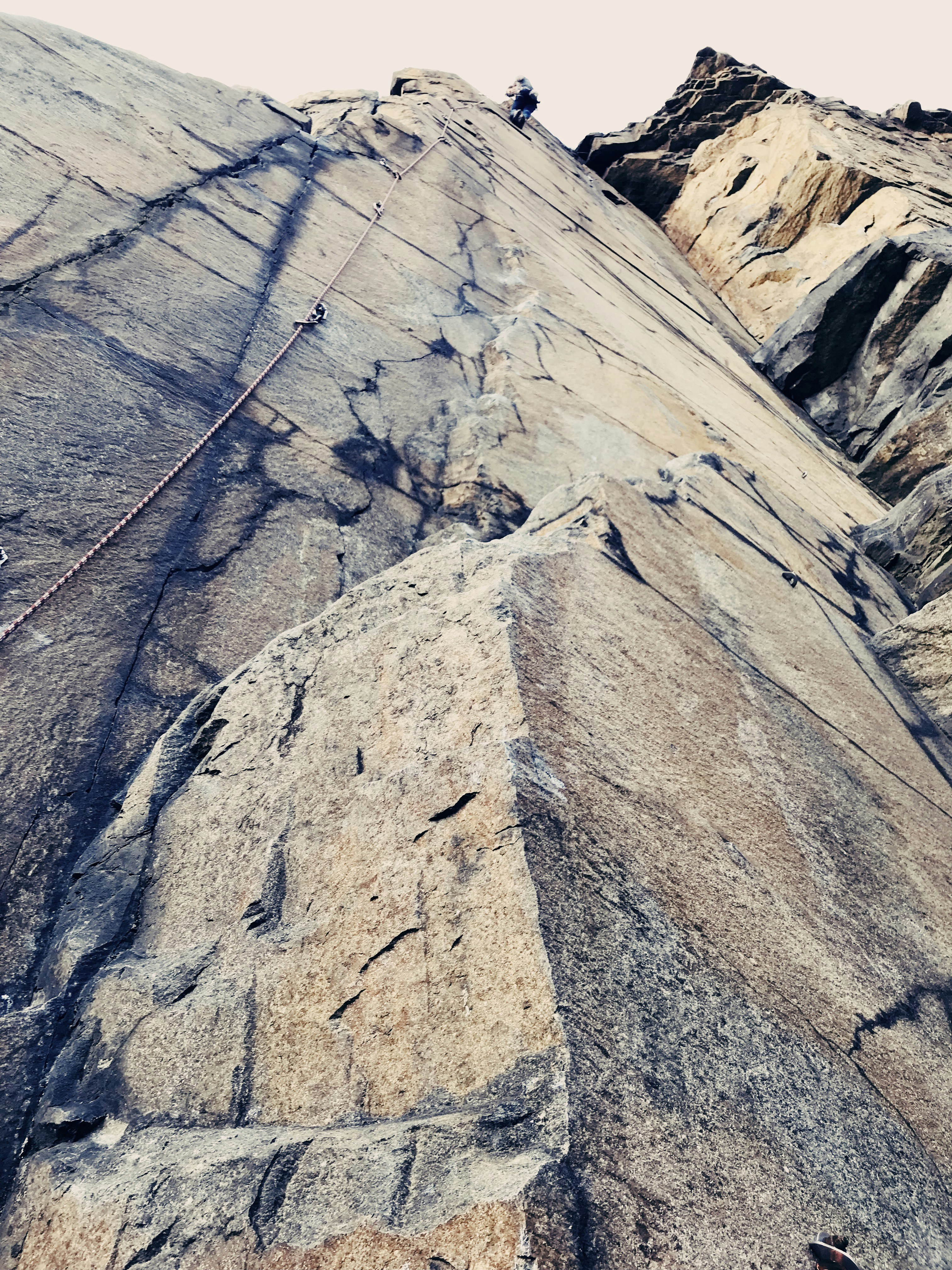 a man climbing up the side of a mountain
