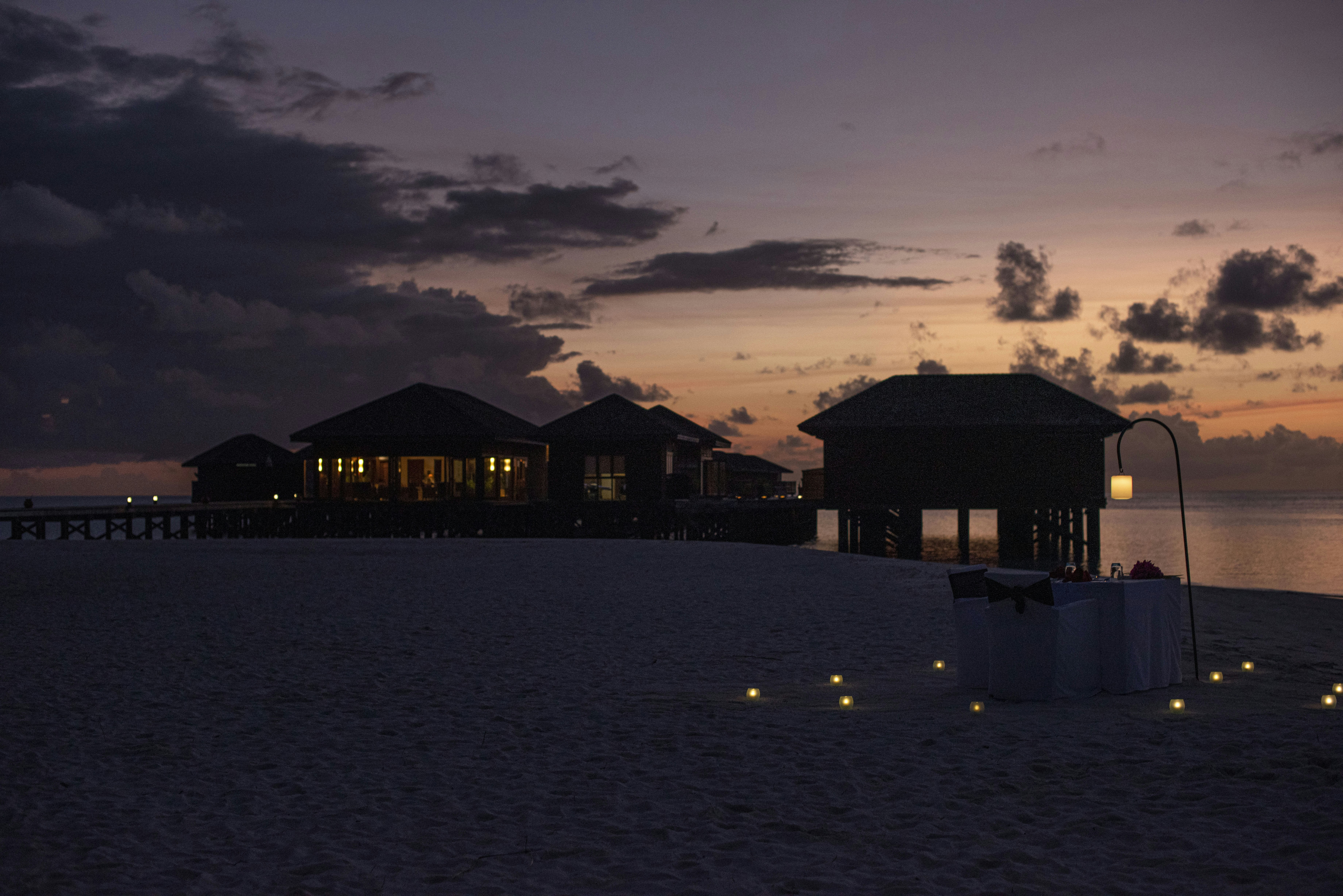 Twilight Lanterns Over Water: Quiet Dusk at the Beach Cabins