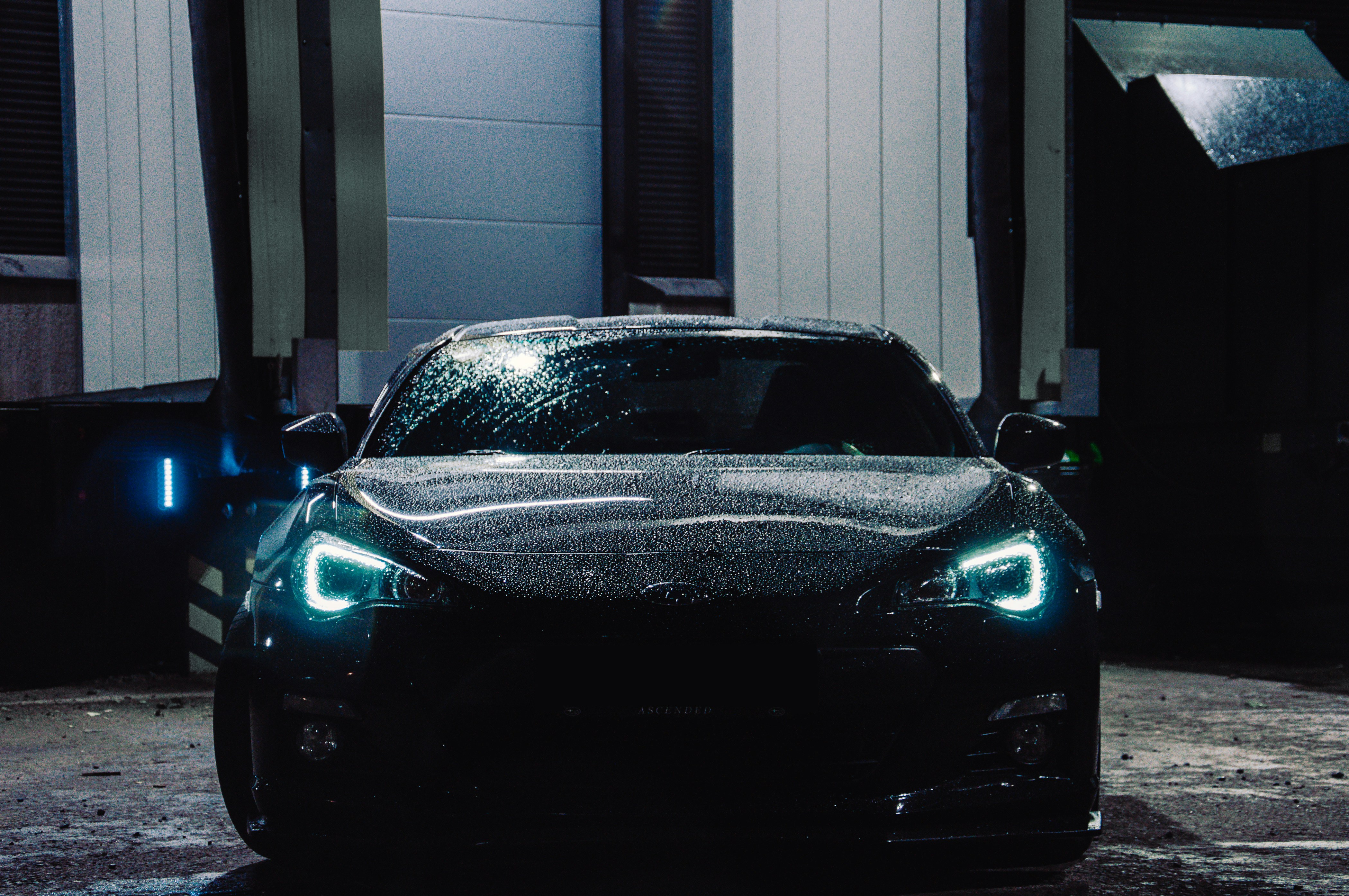 Front-Row Chill: Ice-Sprayed Sedan with Neon-Blue Headlights in a Quiet Courtyard