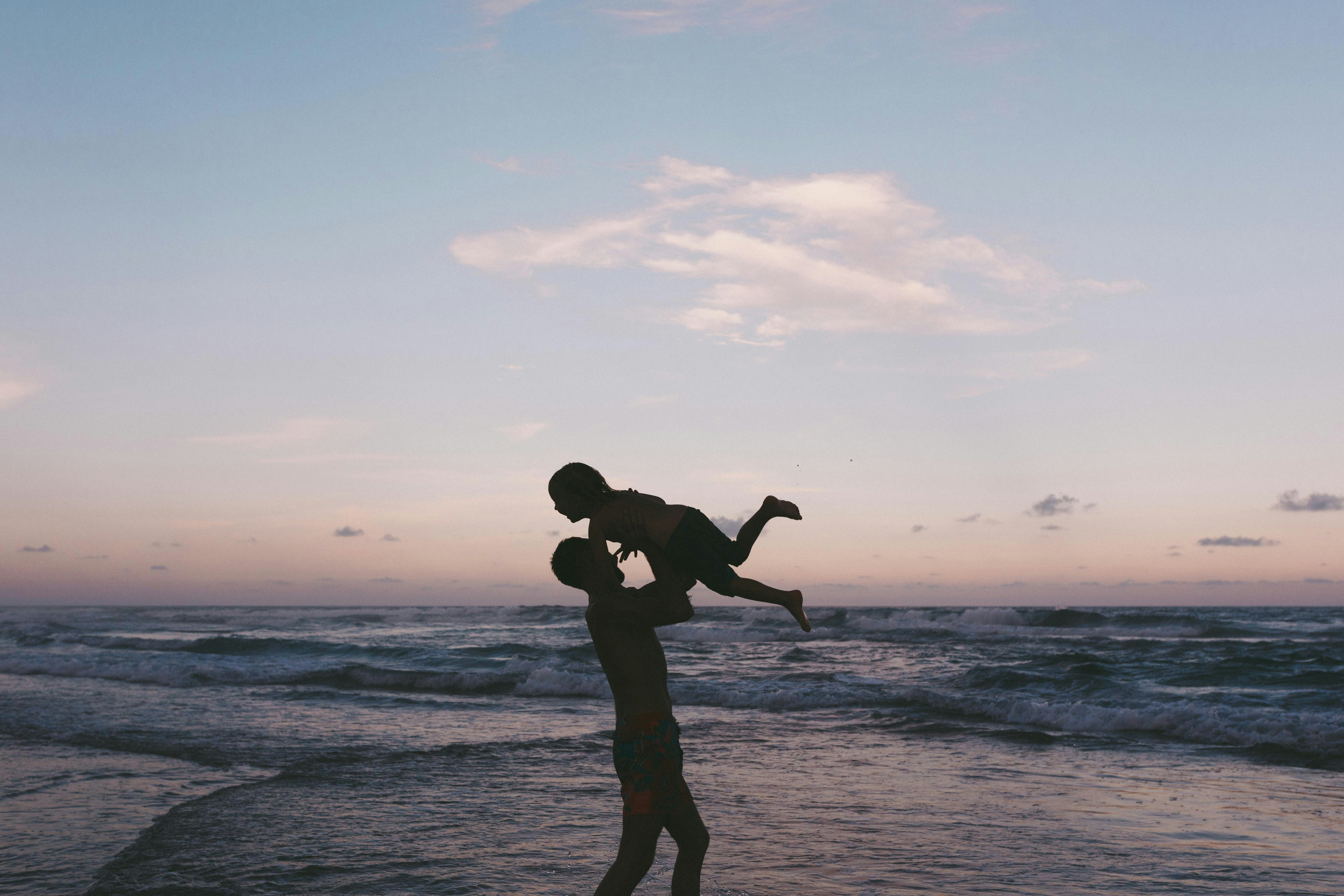 Man carrying baby in seashore photo – Free Grey Image on Unsplash