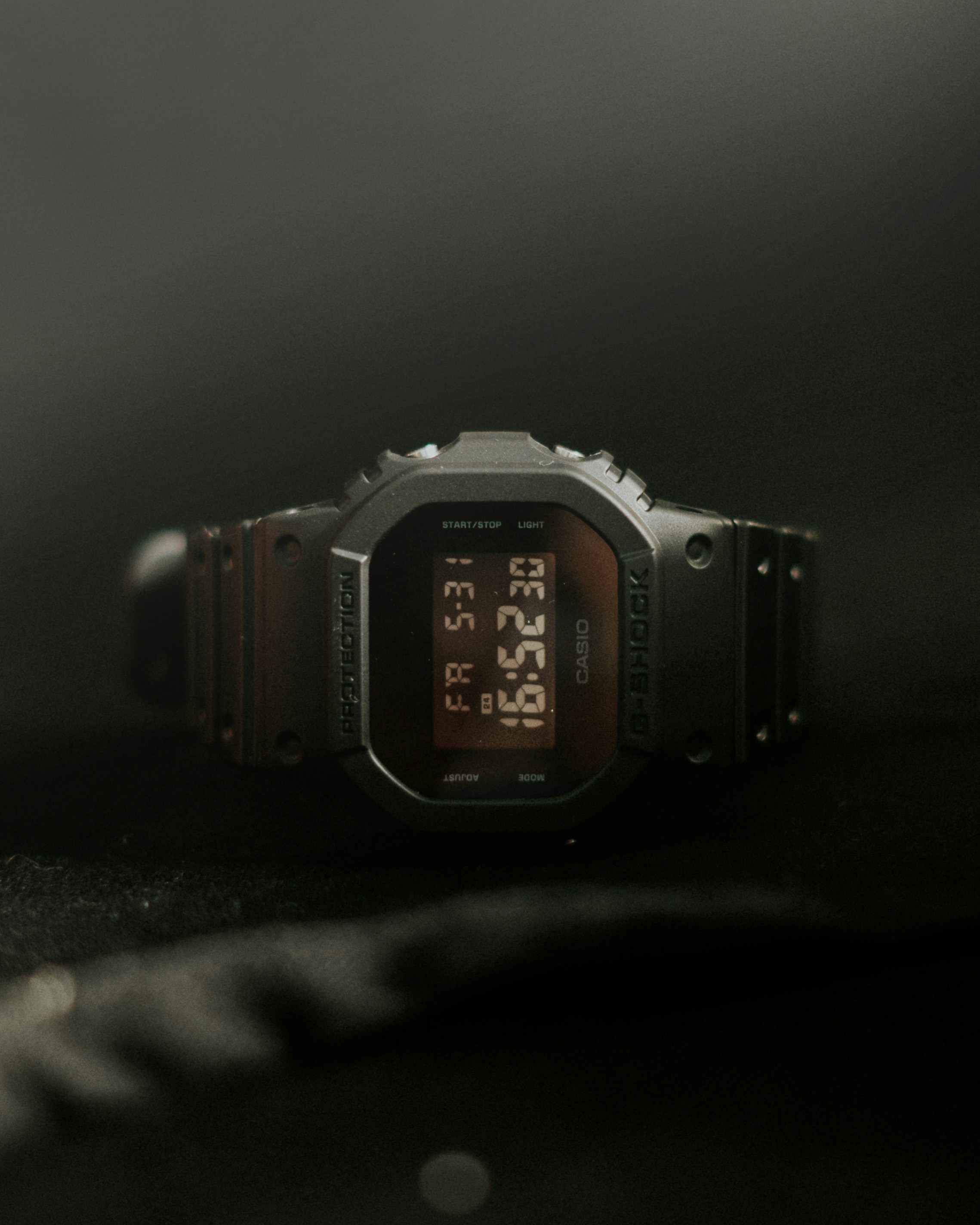 Shadowed Timekeeper: A Casio Digital Watch Resting on Velvet Darkness