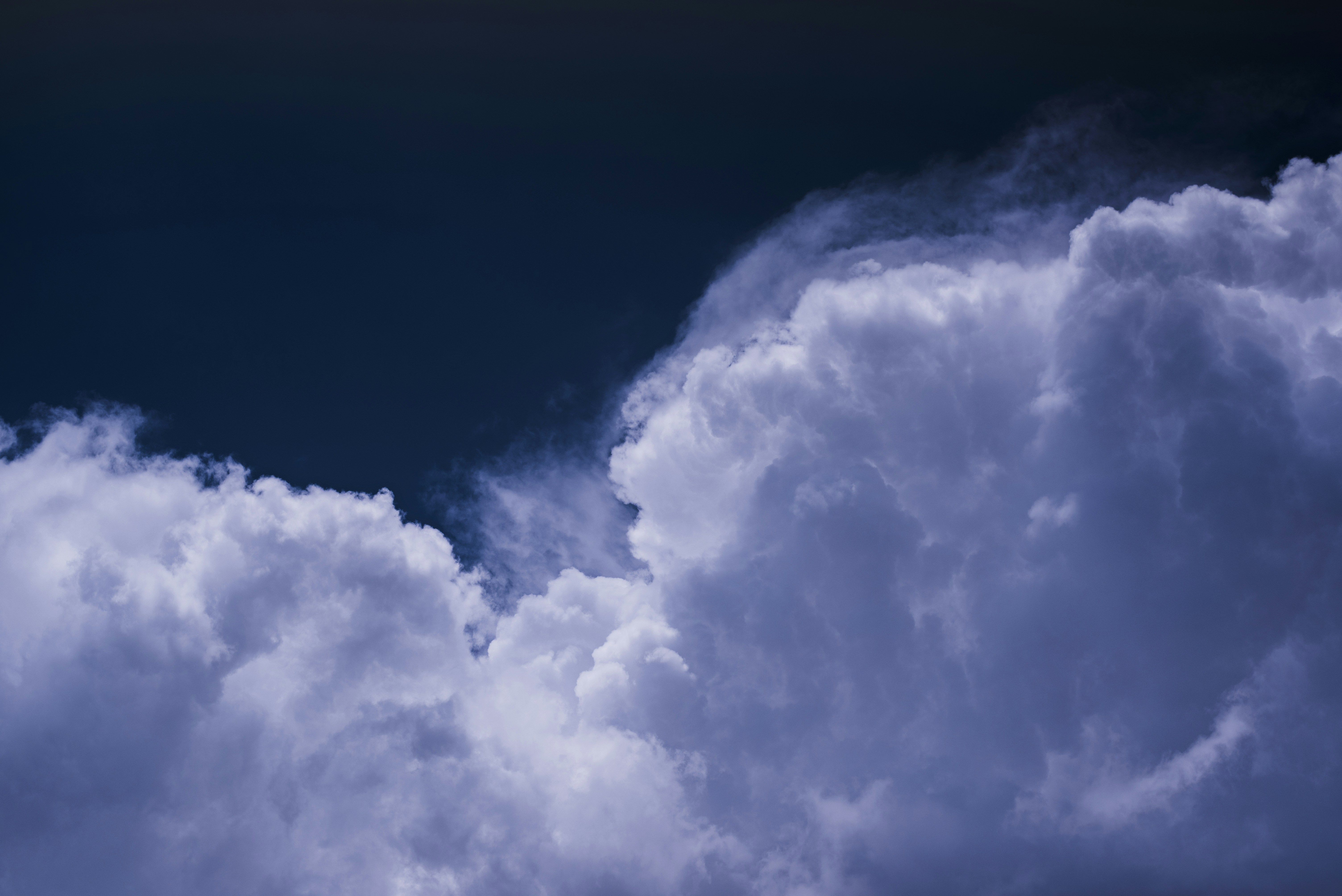 Fluffy clouds swirling against a deepening blue sky, evoking a sense of tranquility and wonder.