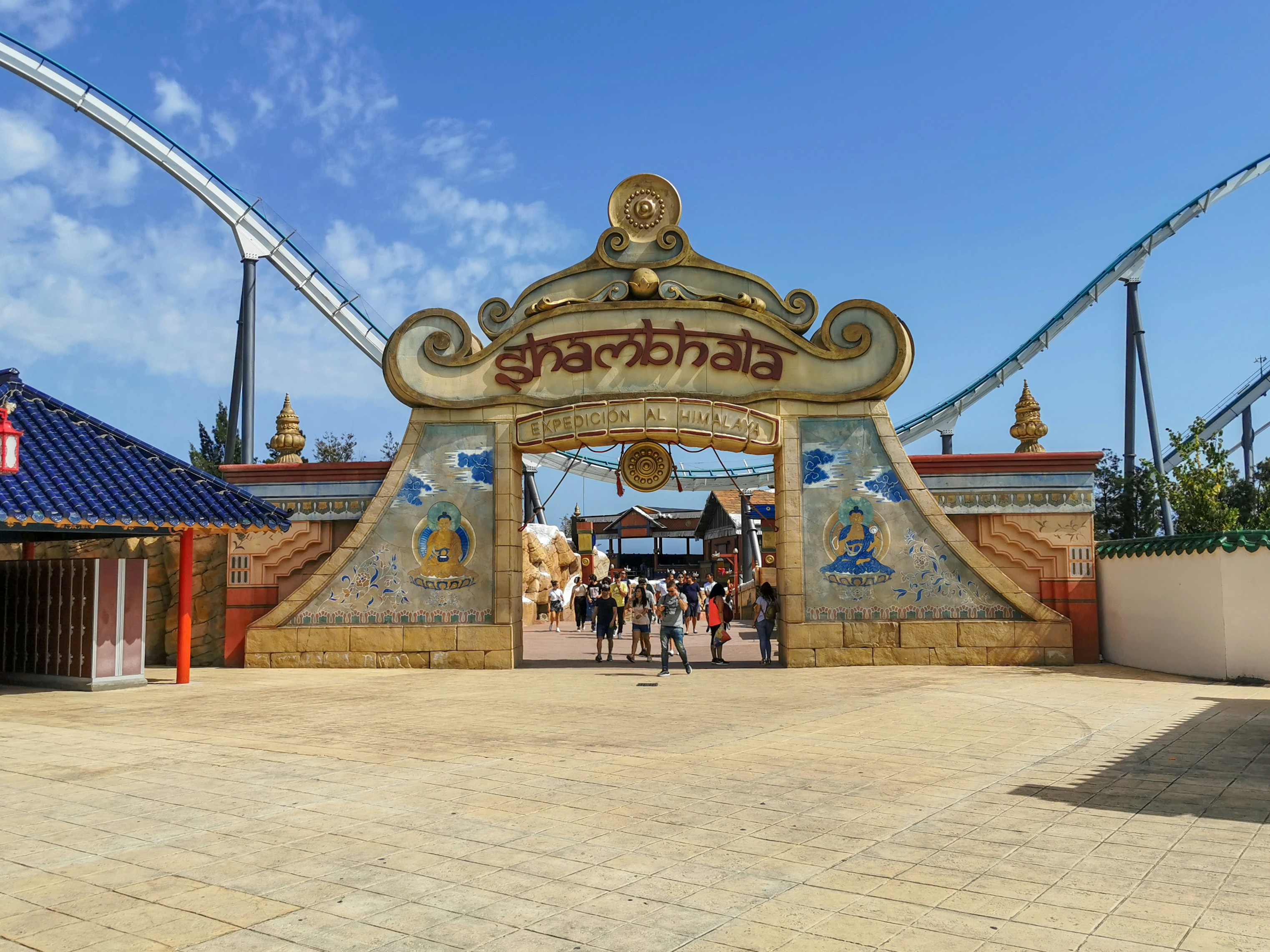 people walking near amusement park under blue and white skies during daytime