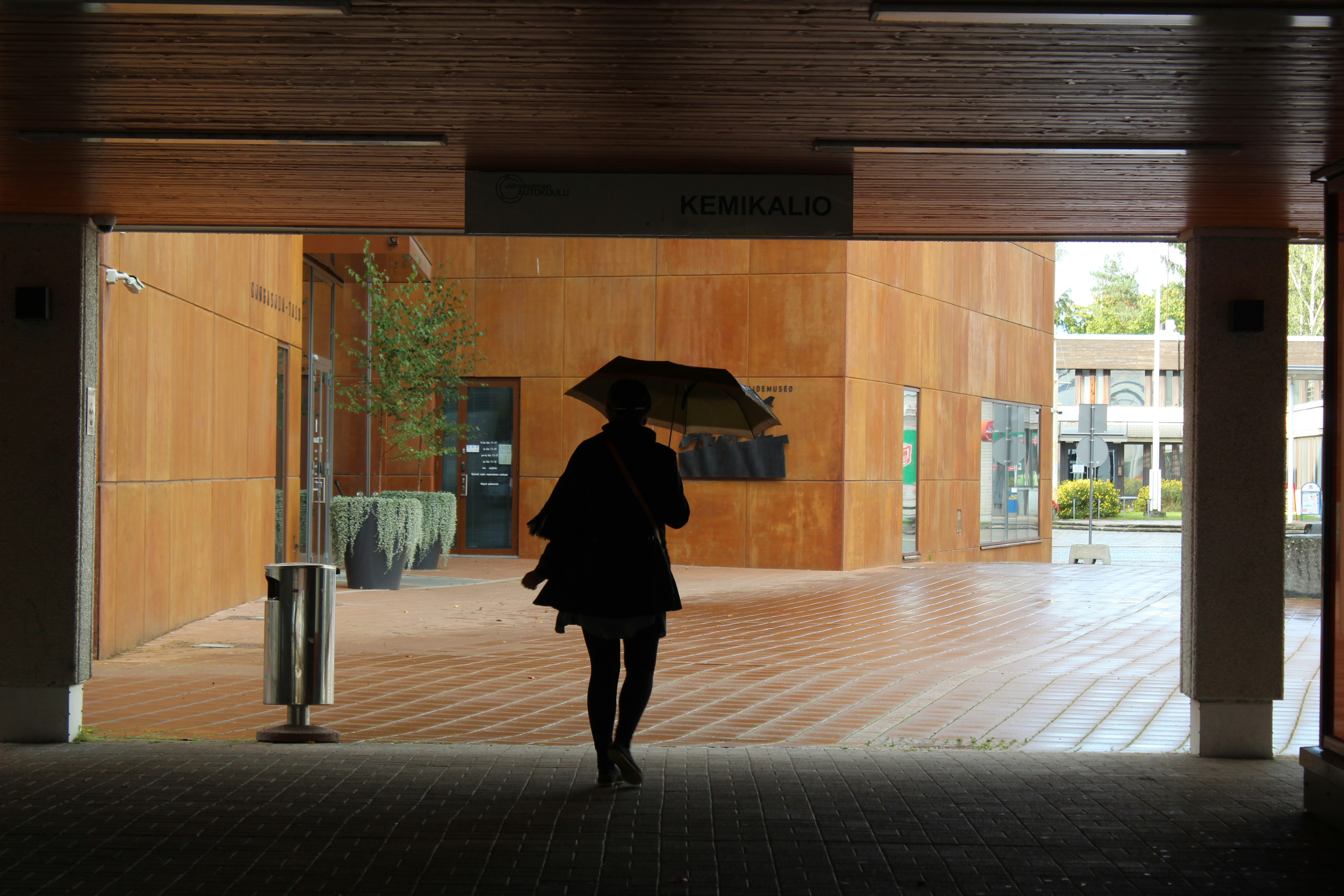 person walking with umbrella near building