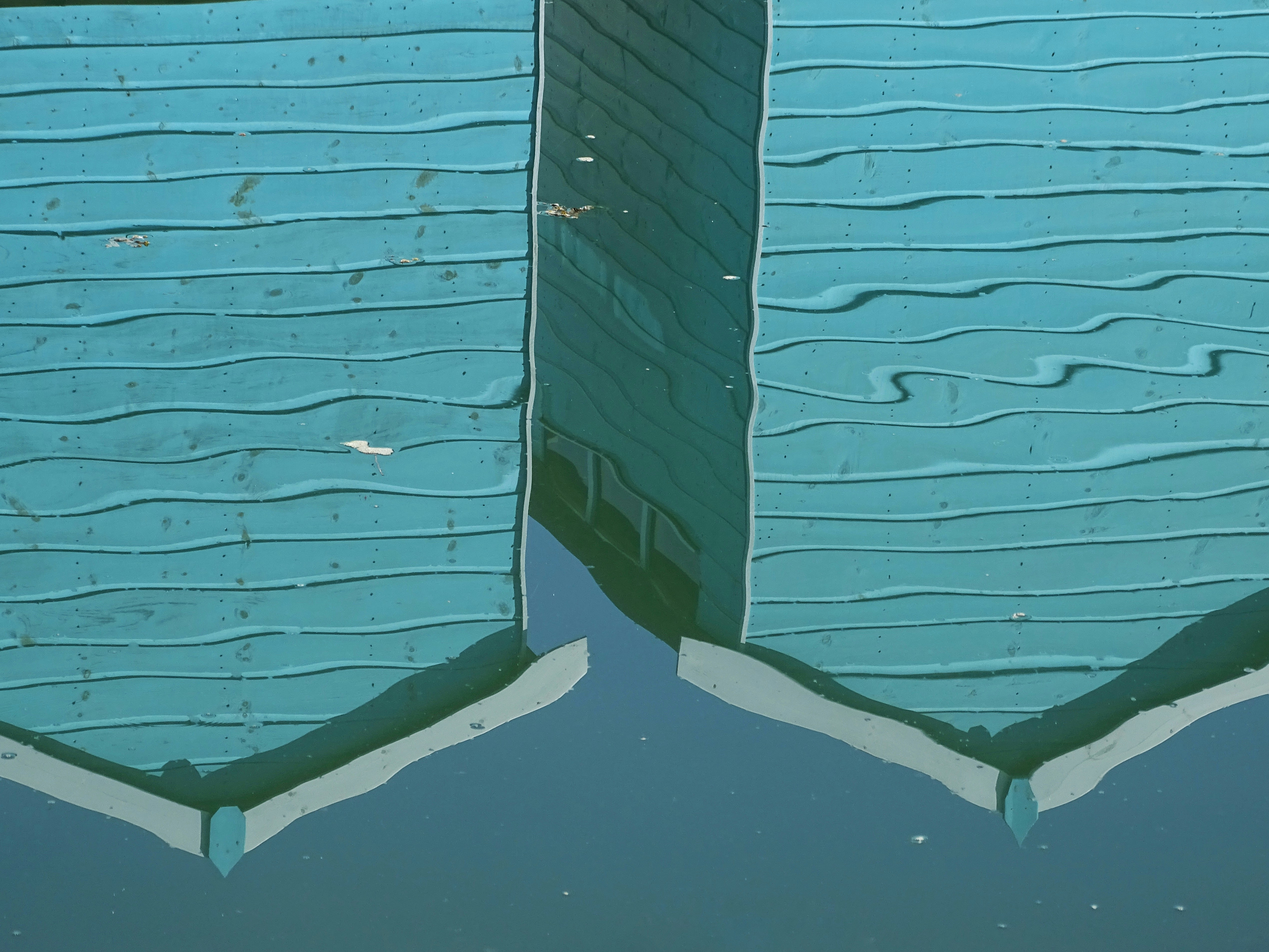 Beach Huts reflecting in the still water a slight almost unnoticeable ripple.  